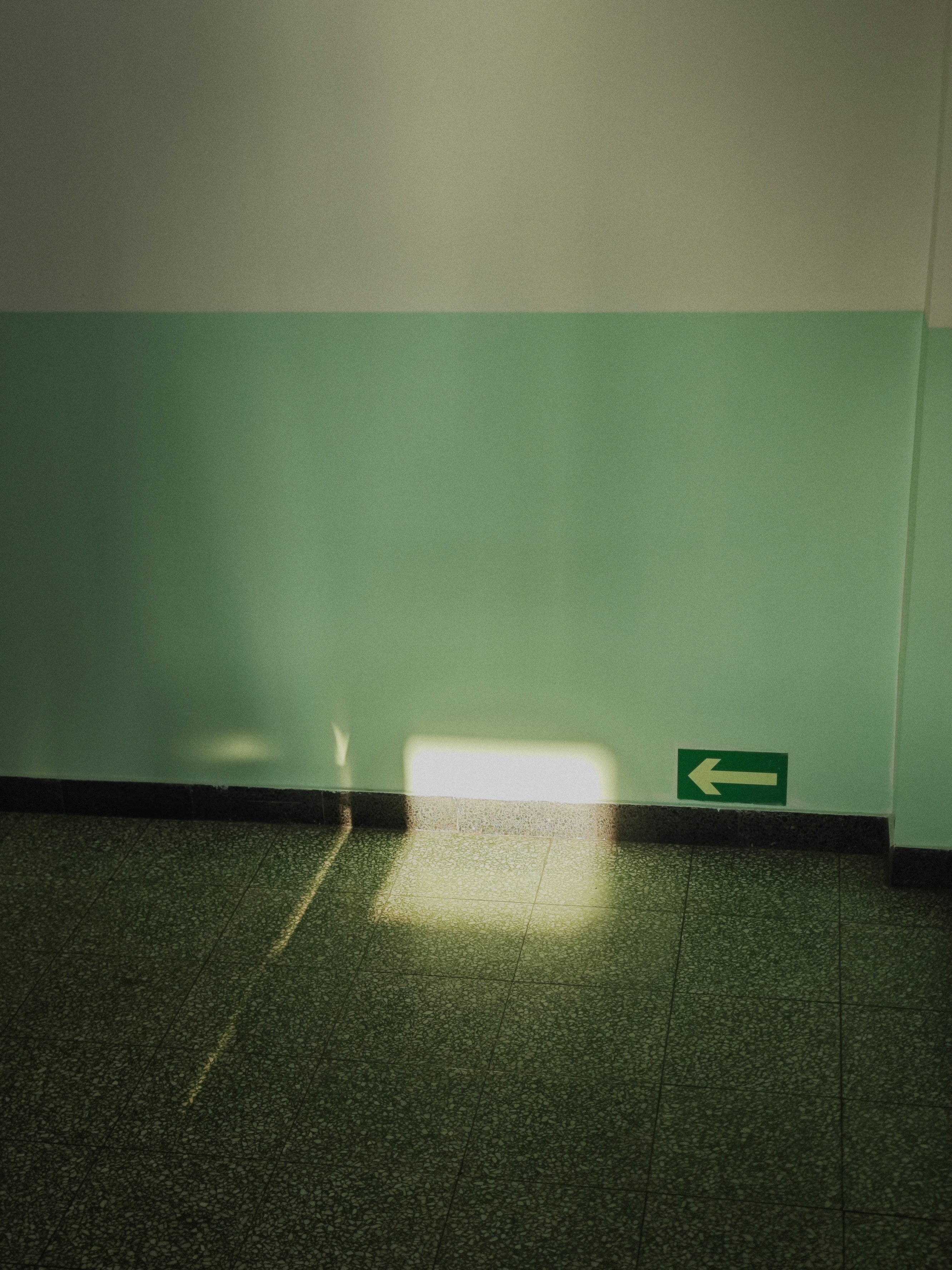 Sunlit doorway shadow: a square glow on a quiet station wall