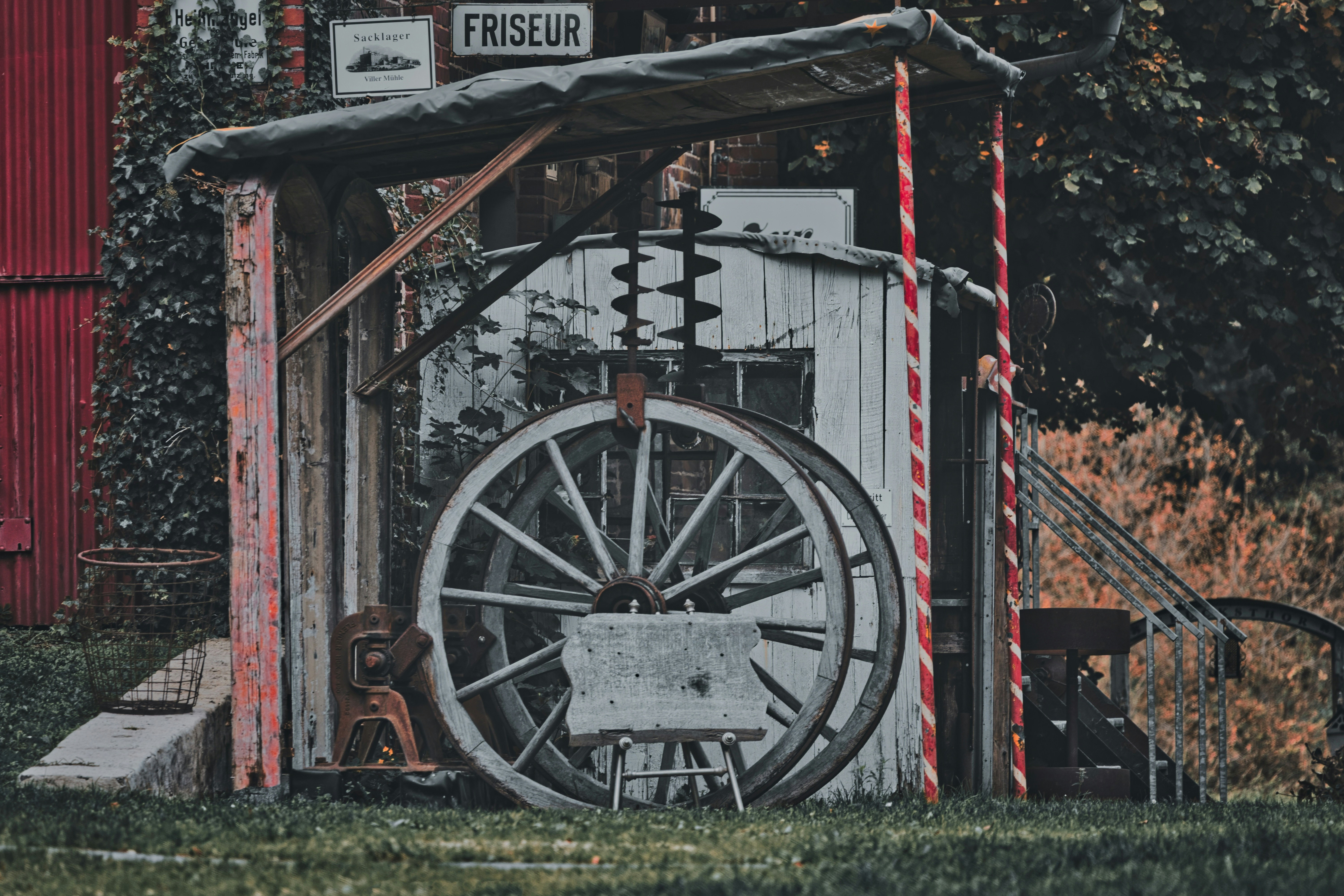 Generational Wheel: A Vintage Cart Wheel Anchored in a Rusted Workshop