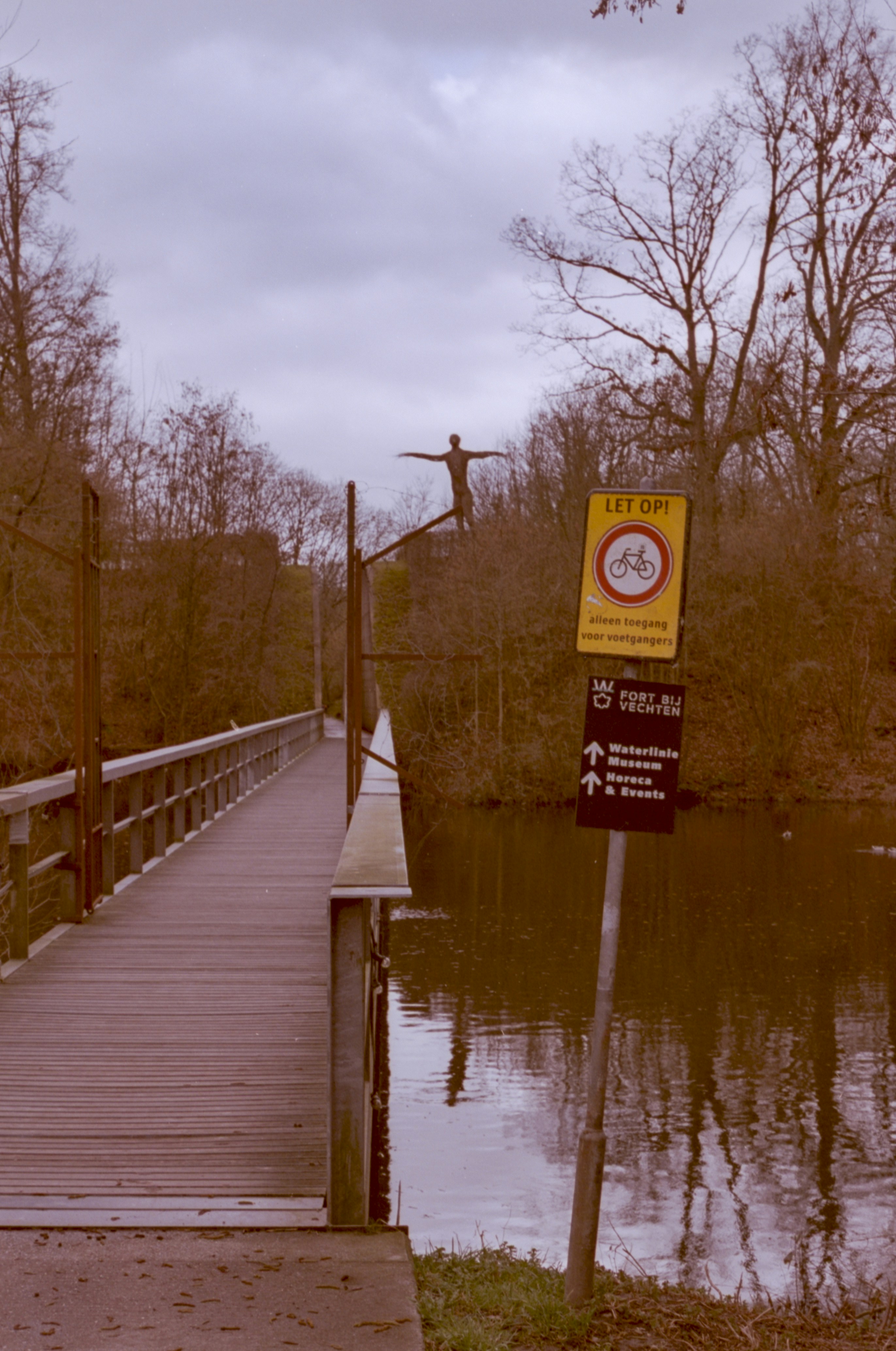 Balance on the Bridge: a lone acrobat over still water