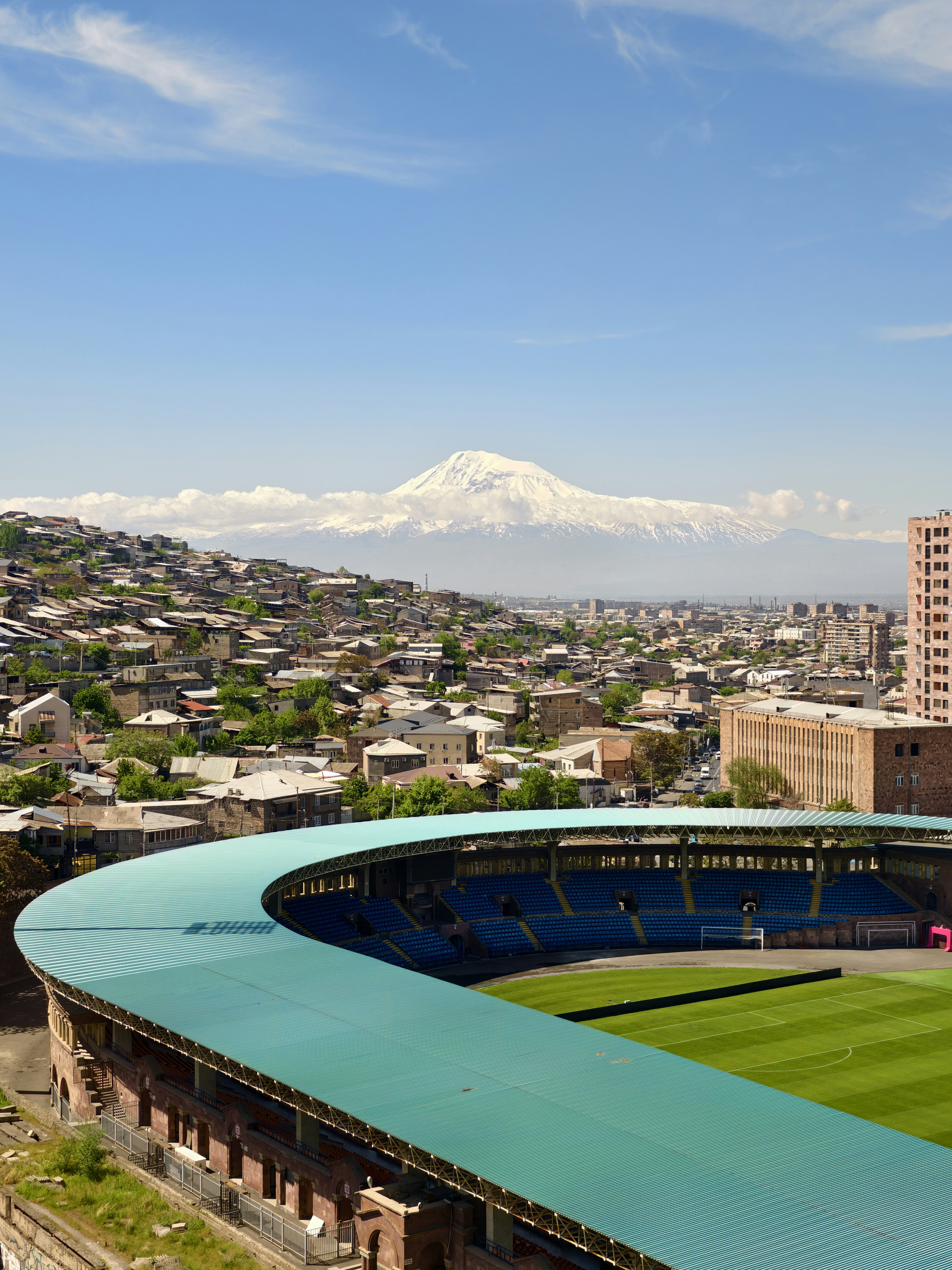 Snow-capped Peak over a Stadium-Tinted Cityscape