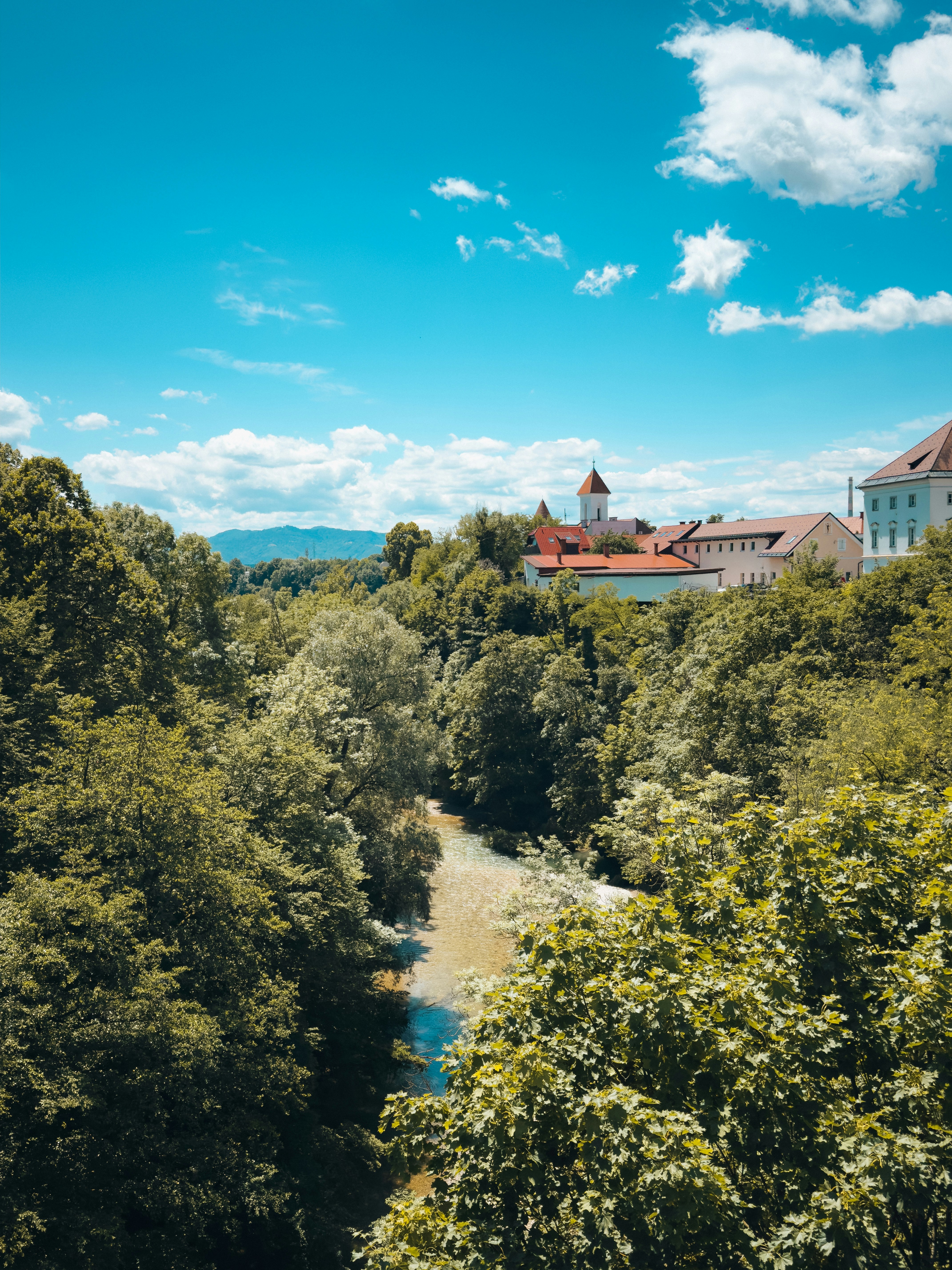 Hilltop manor silhouette above a river bend under a bright sky