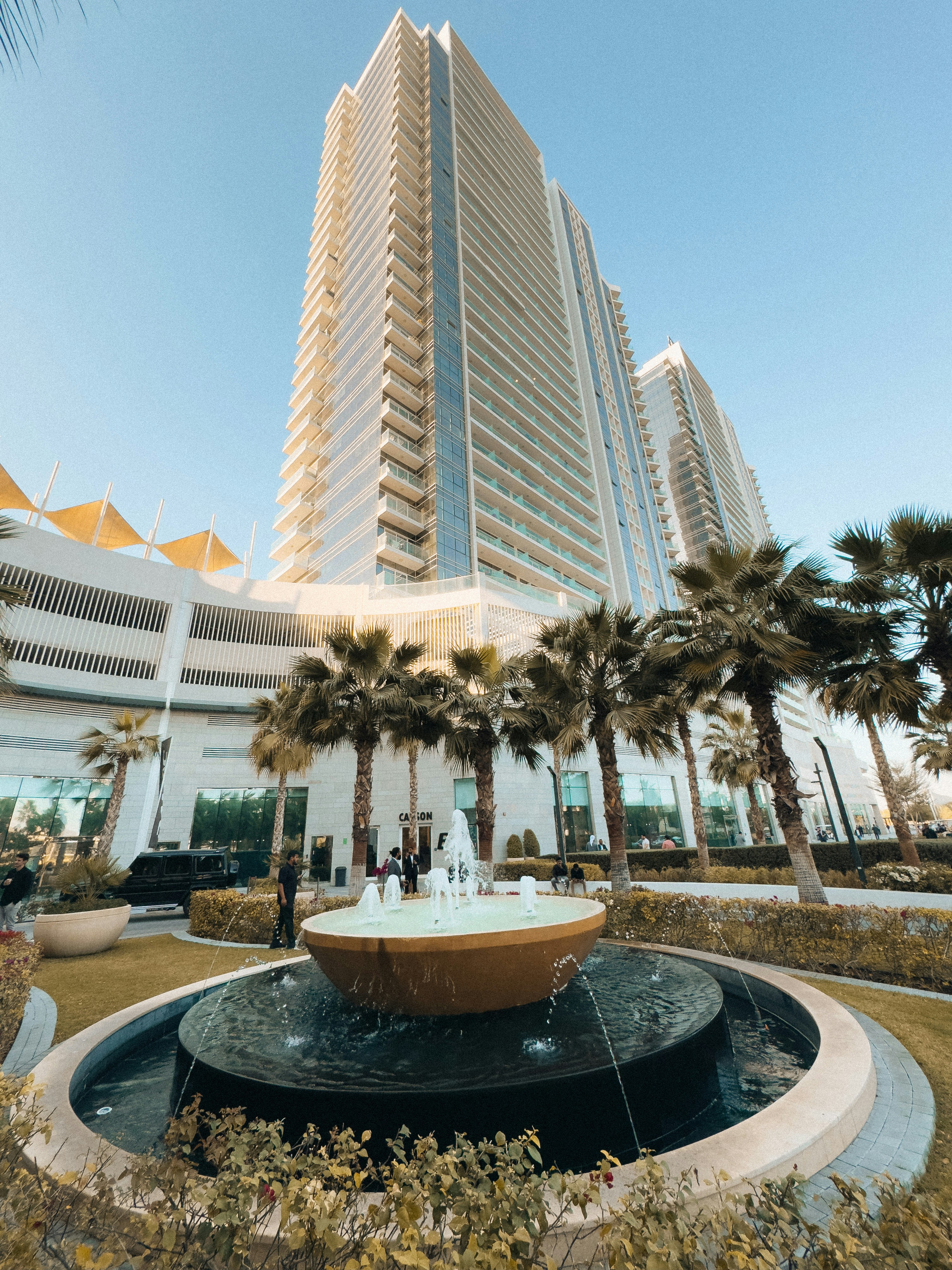 Towering Oasis: Modern High-Rrise Framed by a Circular Fountain Plaza