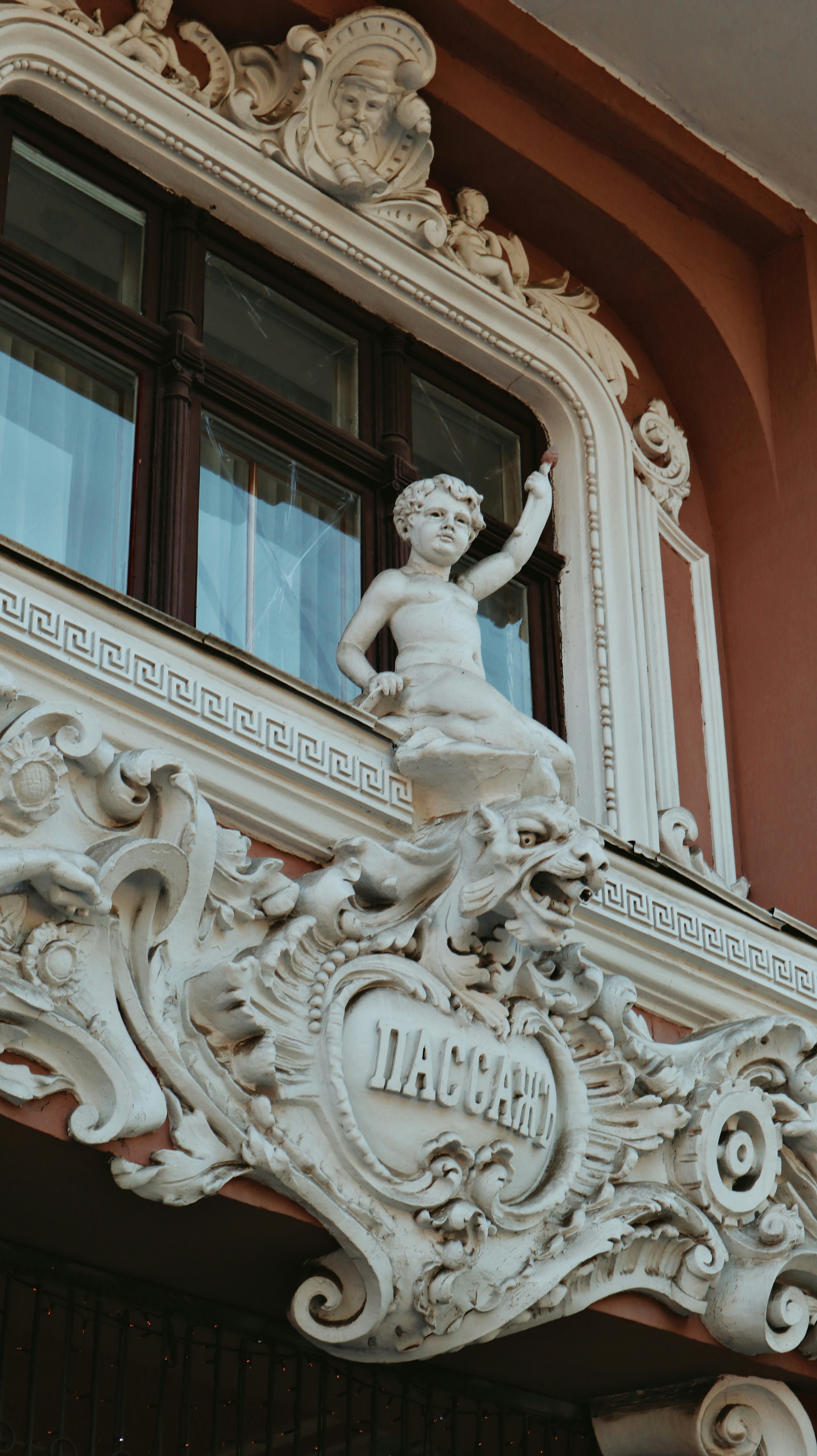 Ornate Façade Sentinel: cherubic statue above carved insignia
