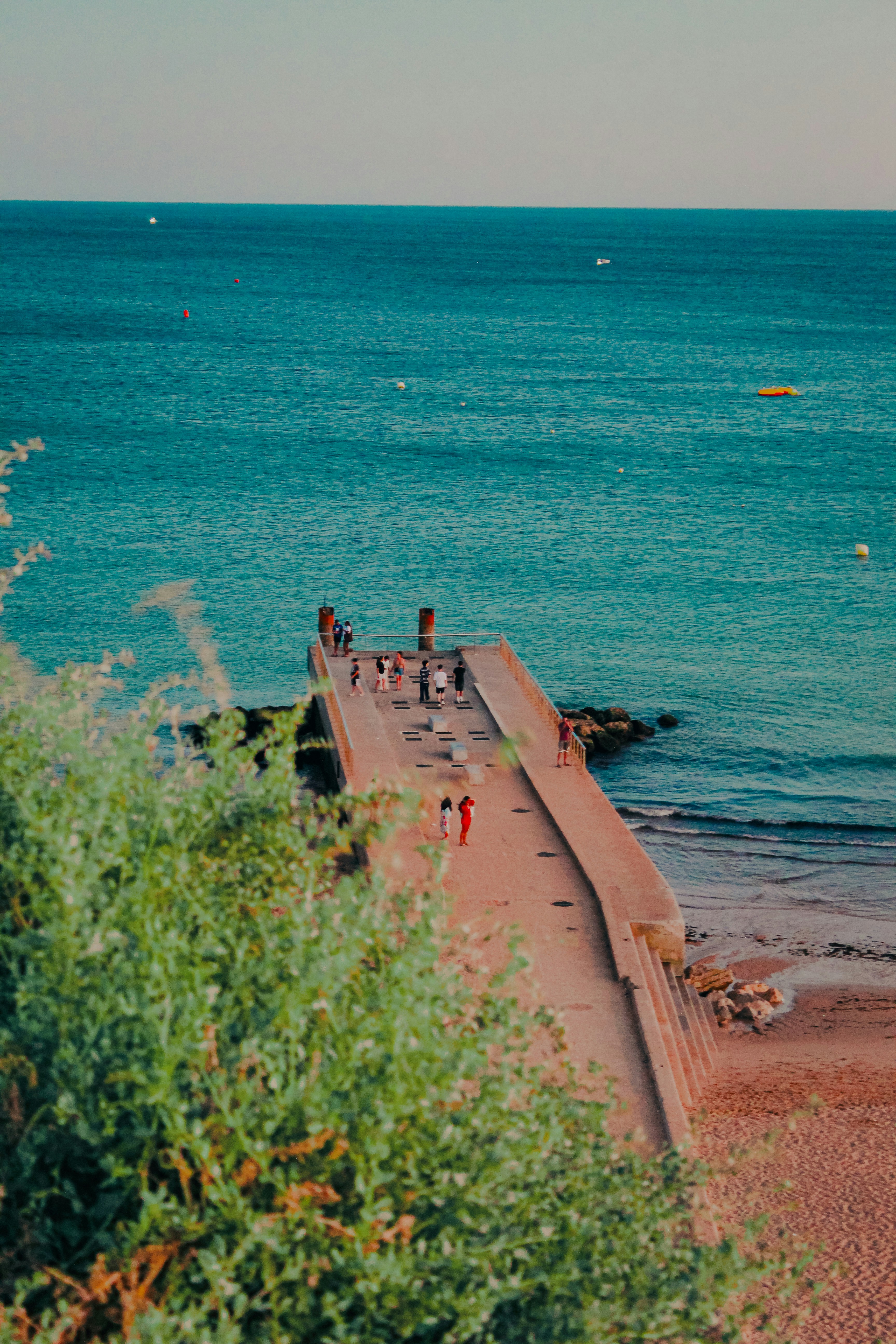 Pier Toward the Horizon: People Walk the Seawall