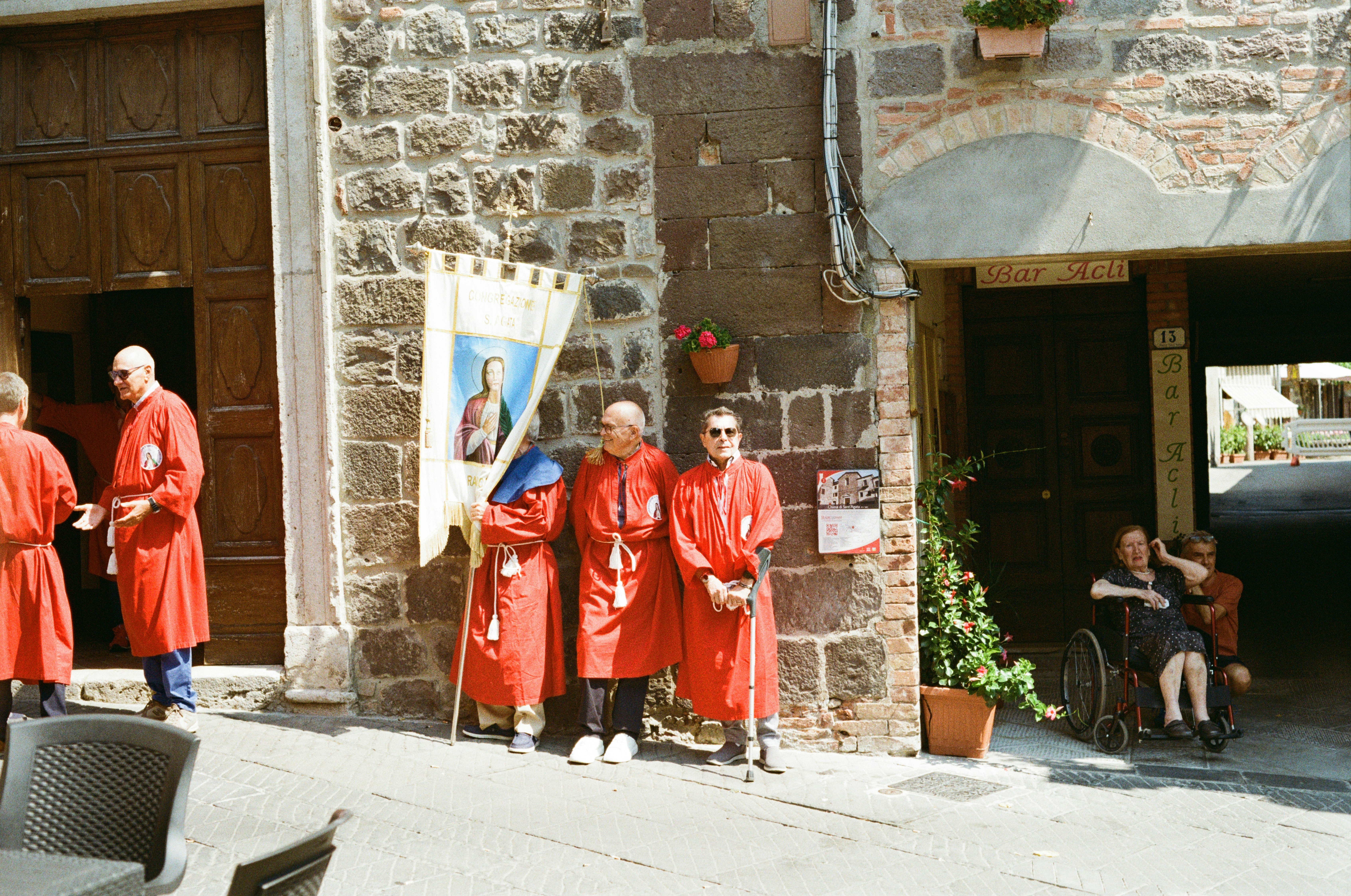 Crimson-robed Guides at a Stone-Arched Street