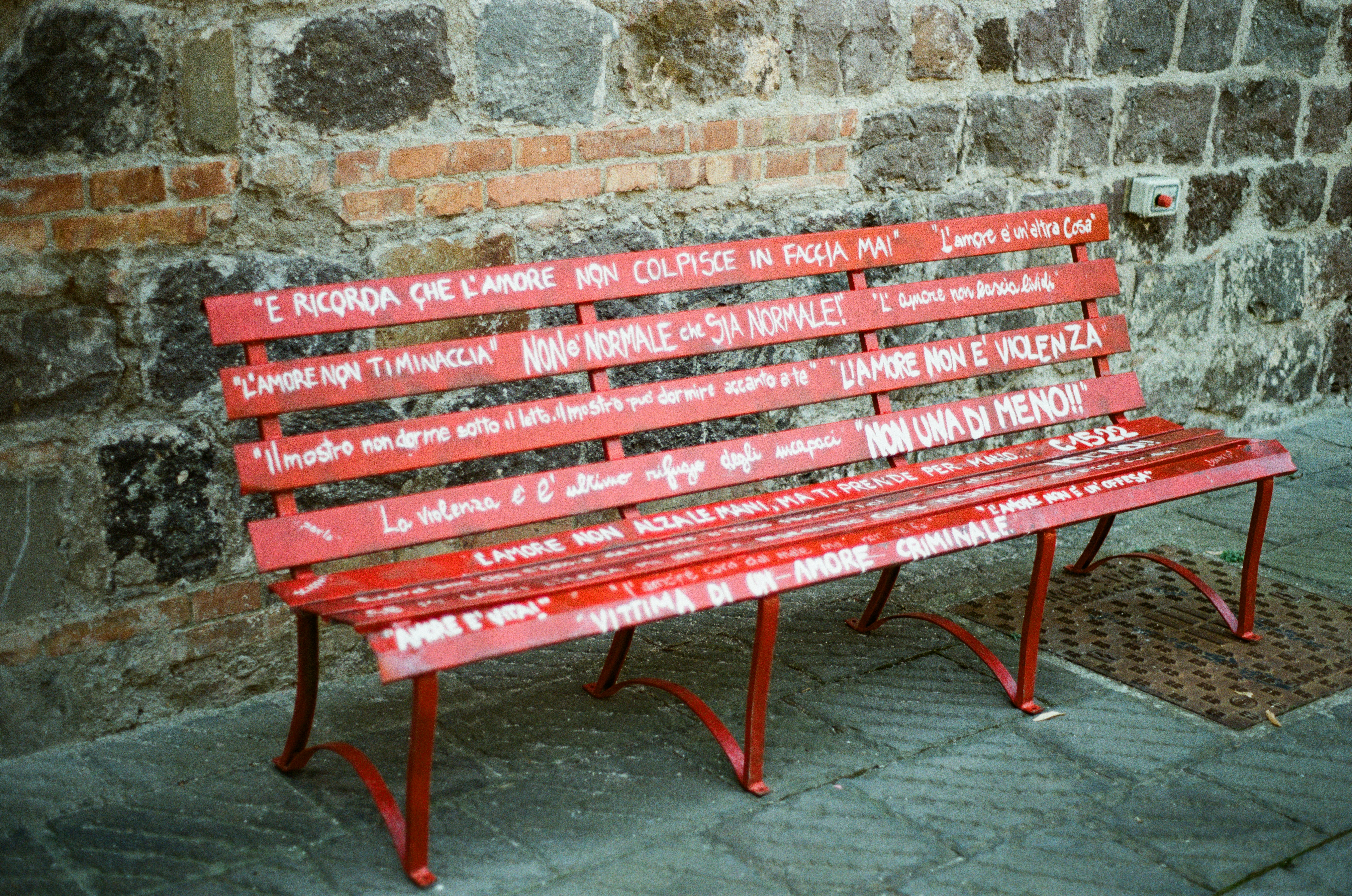 Red Slats, Quiet Street: A Bench Basked in Urban Echoes