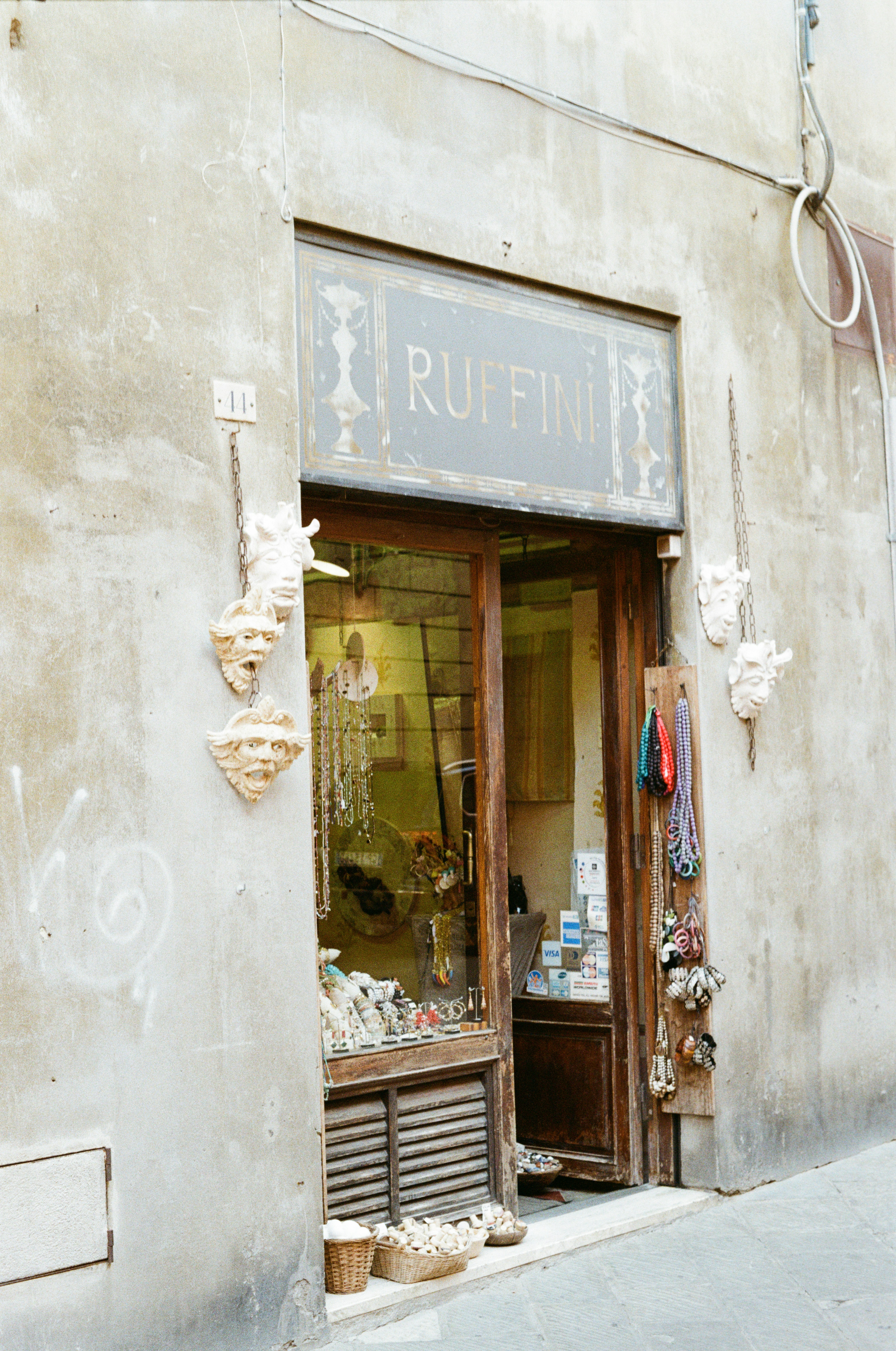 Boutique doorway in weathered European street, with display and hanging cords