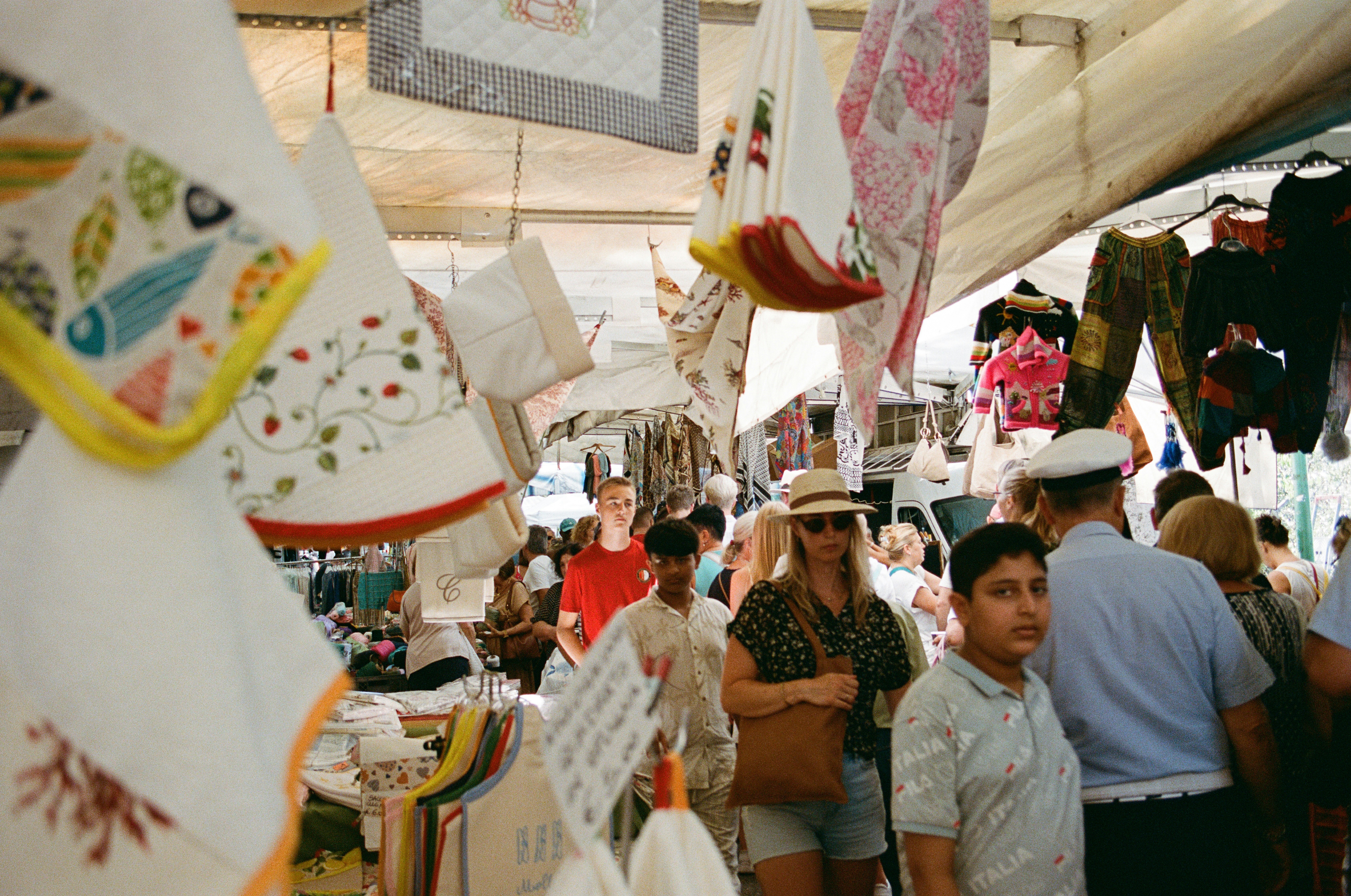 Market Portrait: People Among Printed Fabrics and Colorful Threads