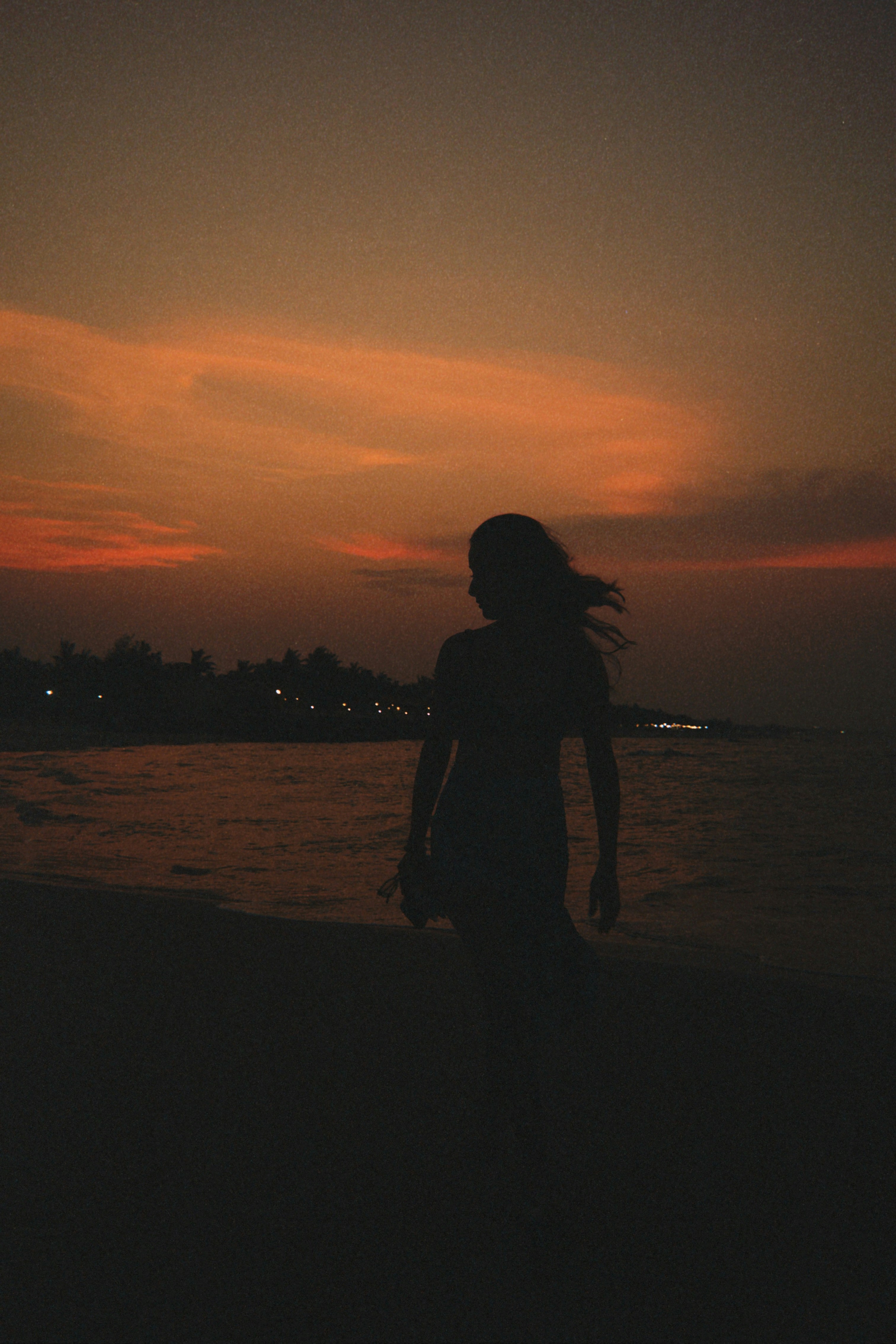 Silhouette at Dusk: A Lone Figure by the Shore