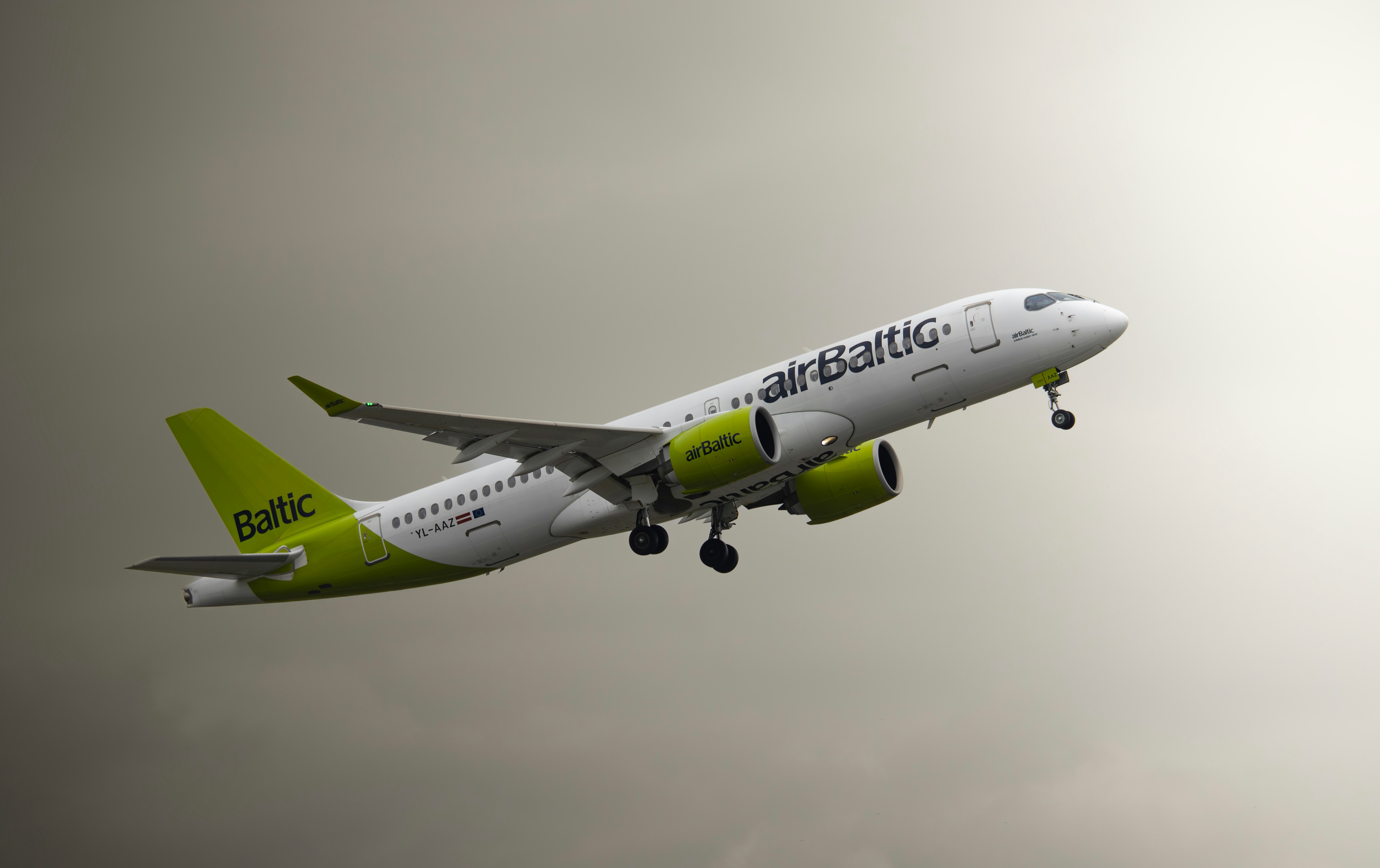 Air Baltic ascent: lime-green livery slicing through moody skies