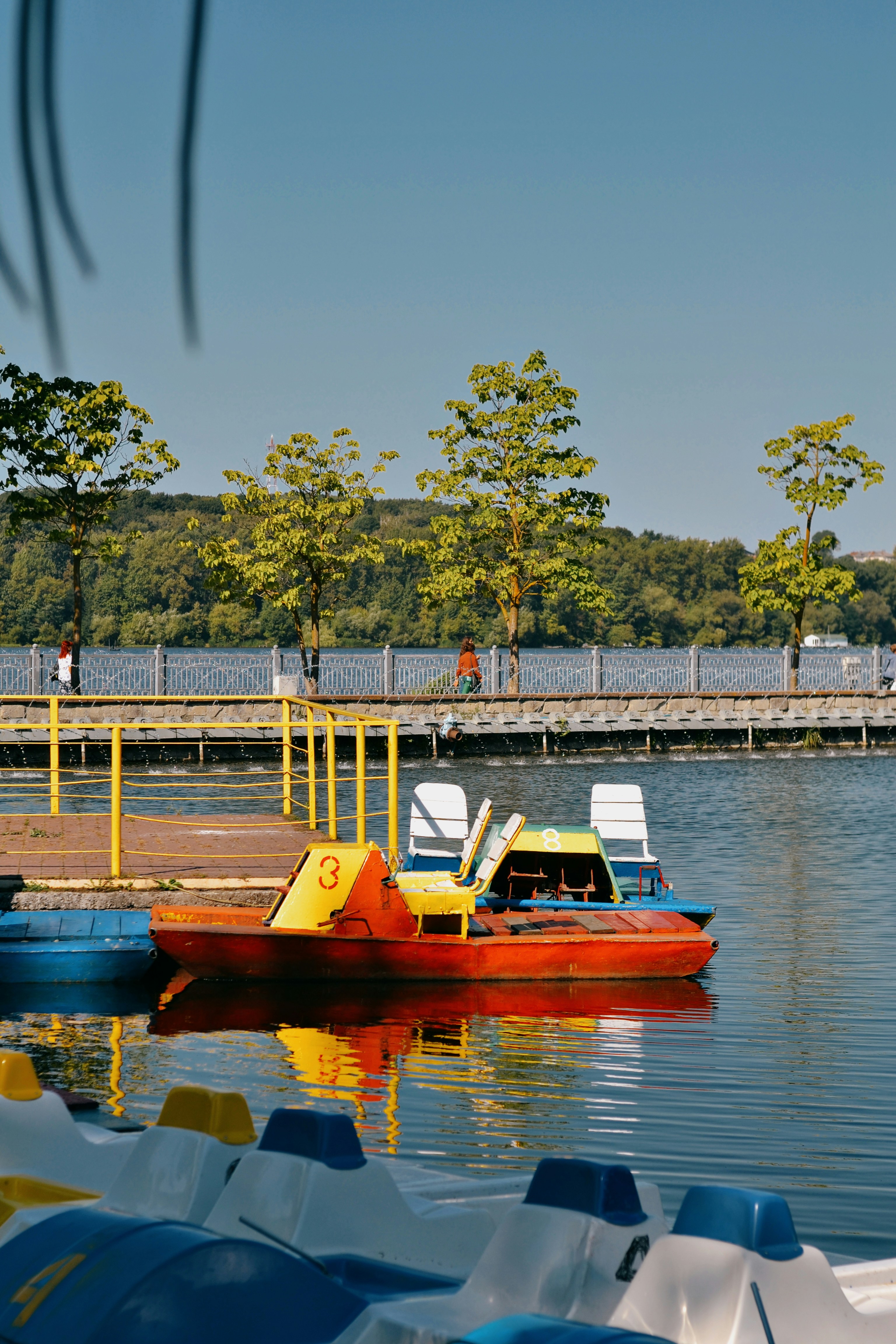 Sunlit Boats at the Pier: Colorful Reflections on Calm Waters
