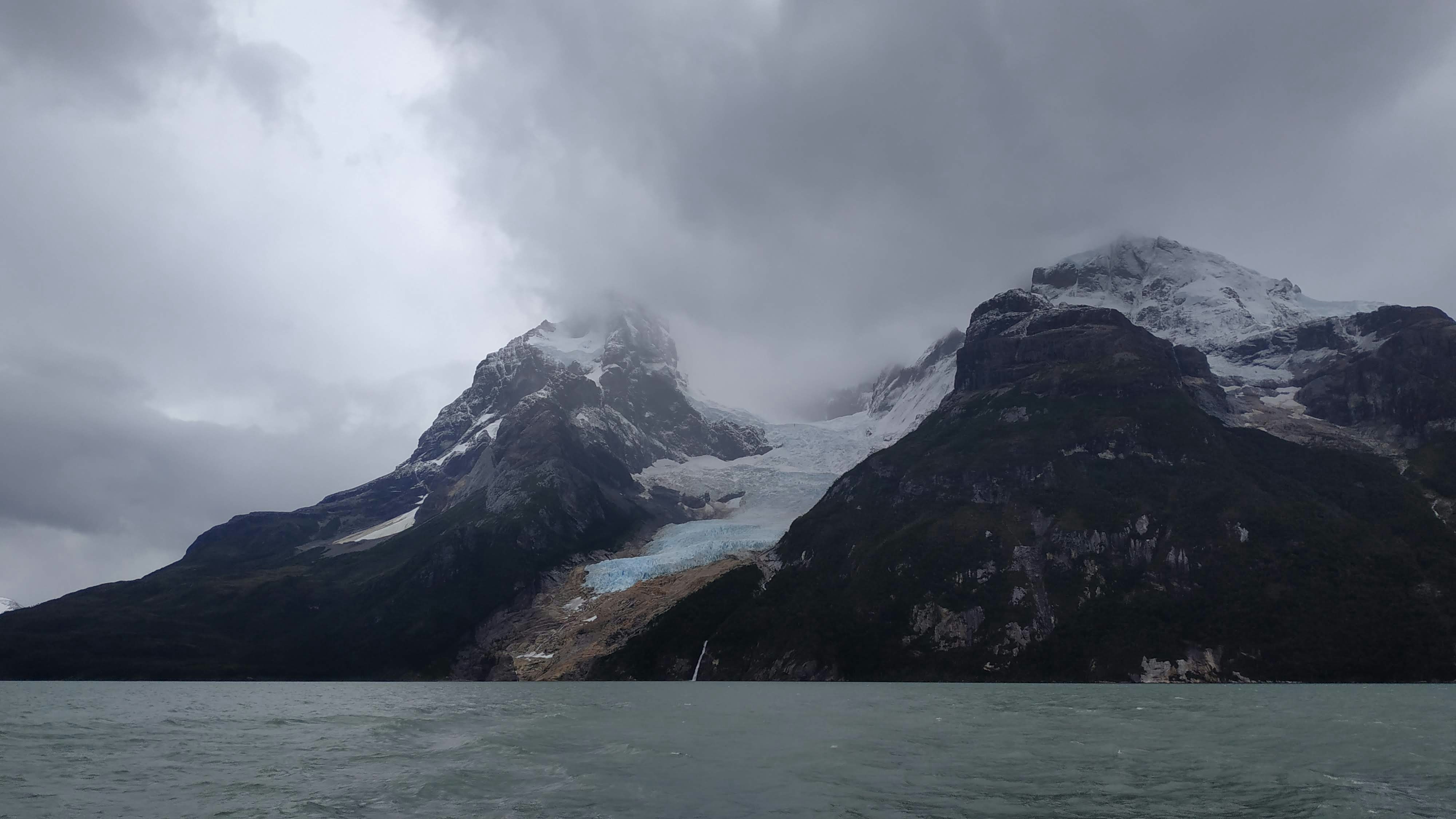Glacial Peaks Eclipsed by Clouds Over Dusk-Tinted Fjord