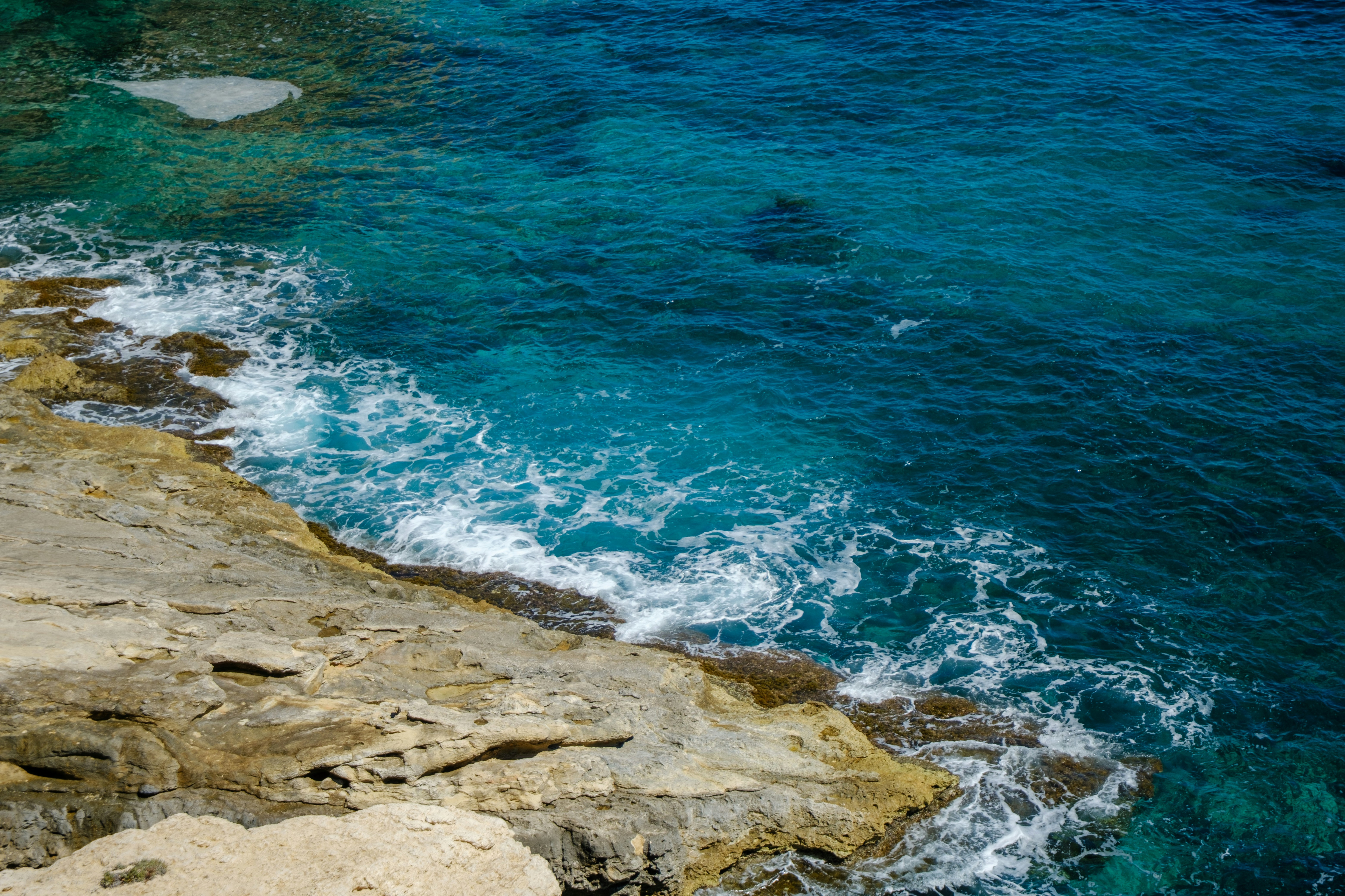 Coastal Cliff Echoes: Turquoise Verge meeting Weathered Stone