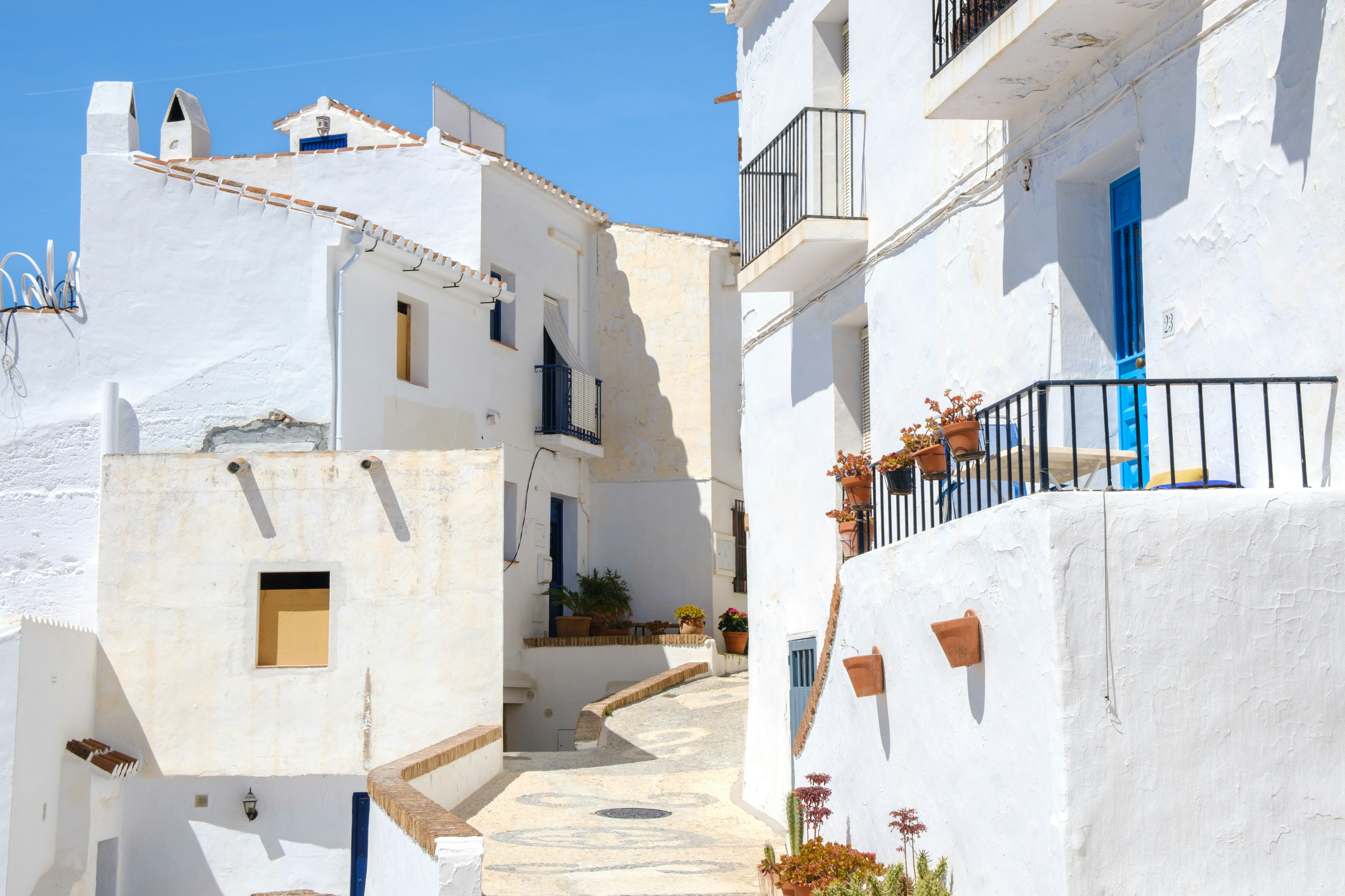 Whitewashed Alleyway to the Sea in Sunlit Santorini-inspired Lane