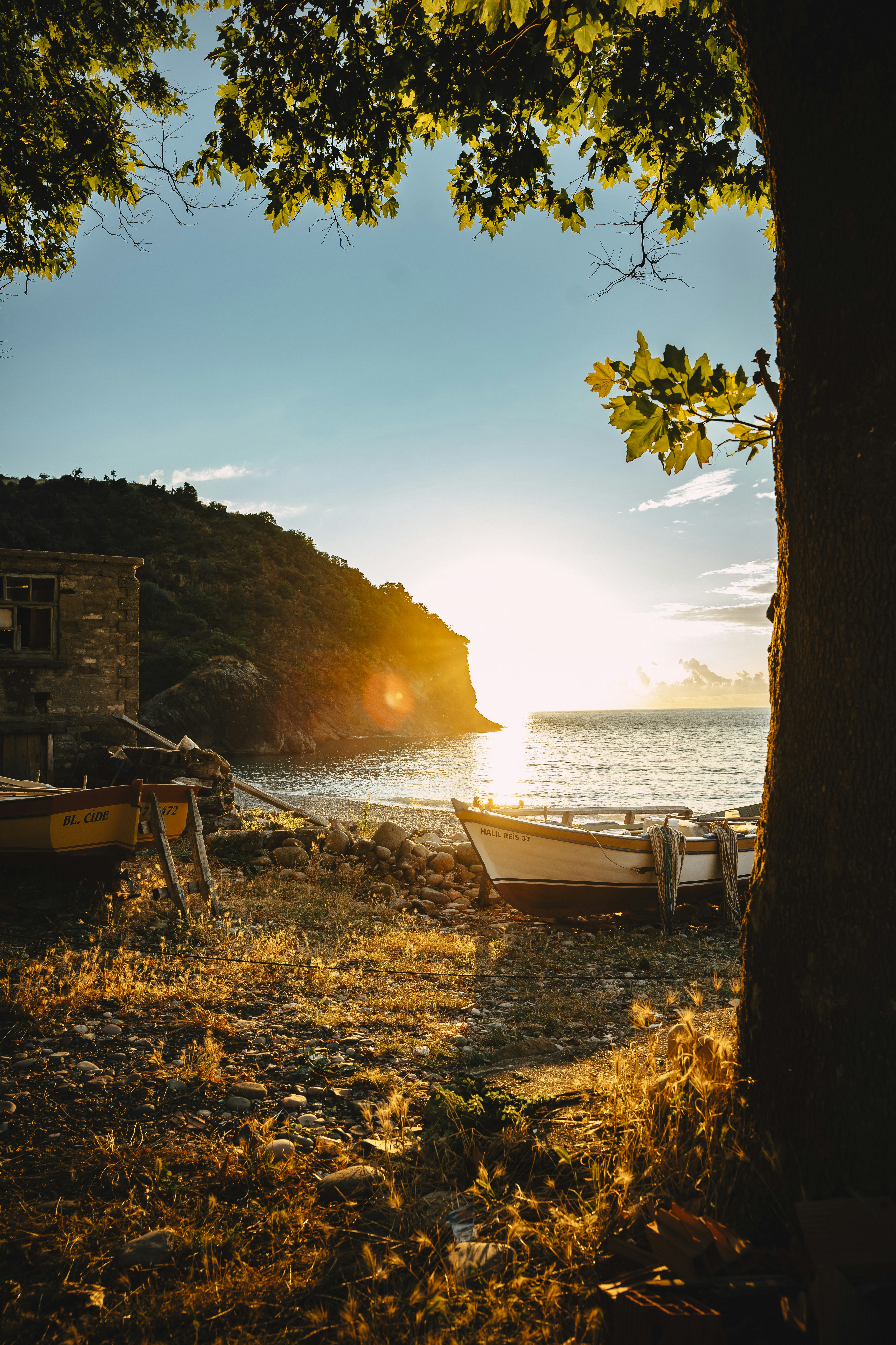 Sunlit Cove: Boats Rest Amid a Quiet Dusk by the Shore