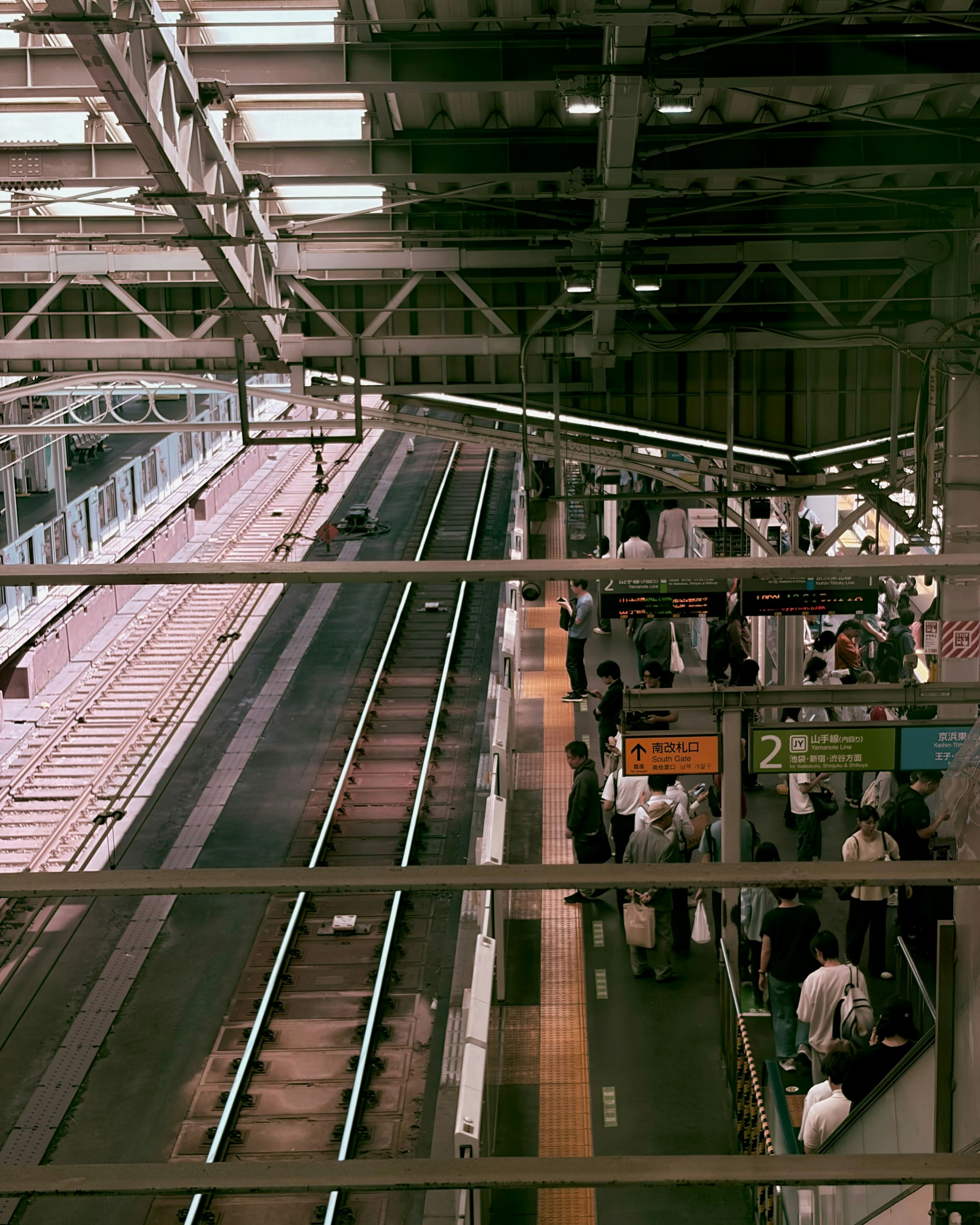 Platform Pulse: Commuters Cast Shadows Under Neon Rails