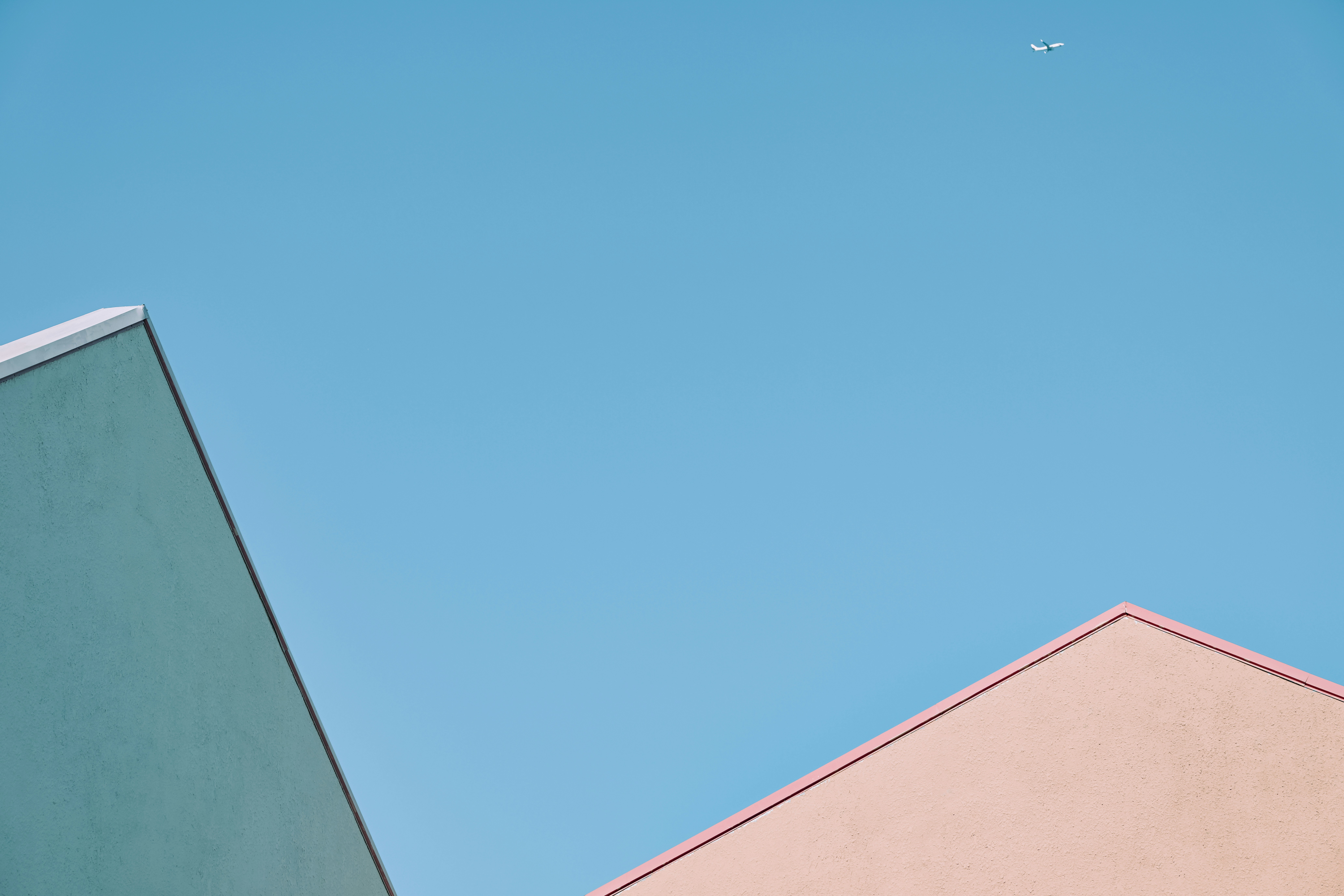 Teal and peach building edges against a clear blue sky.