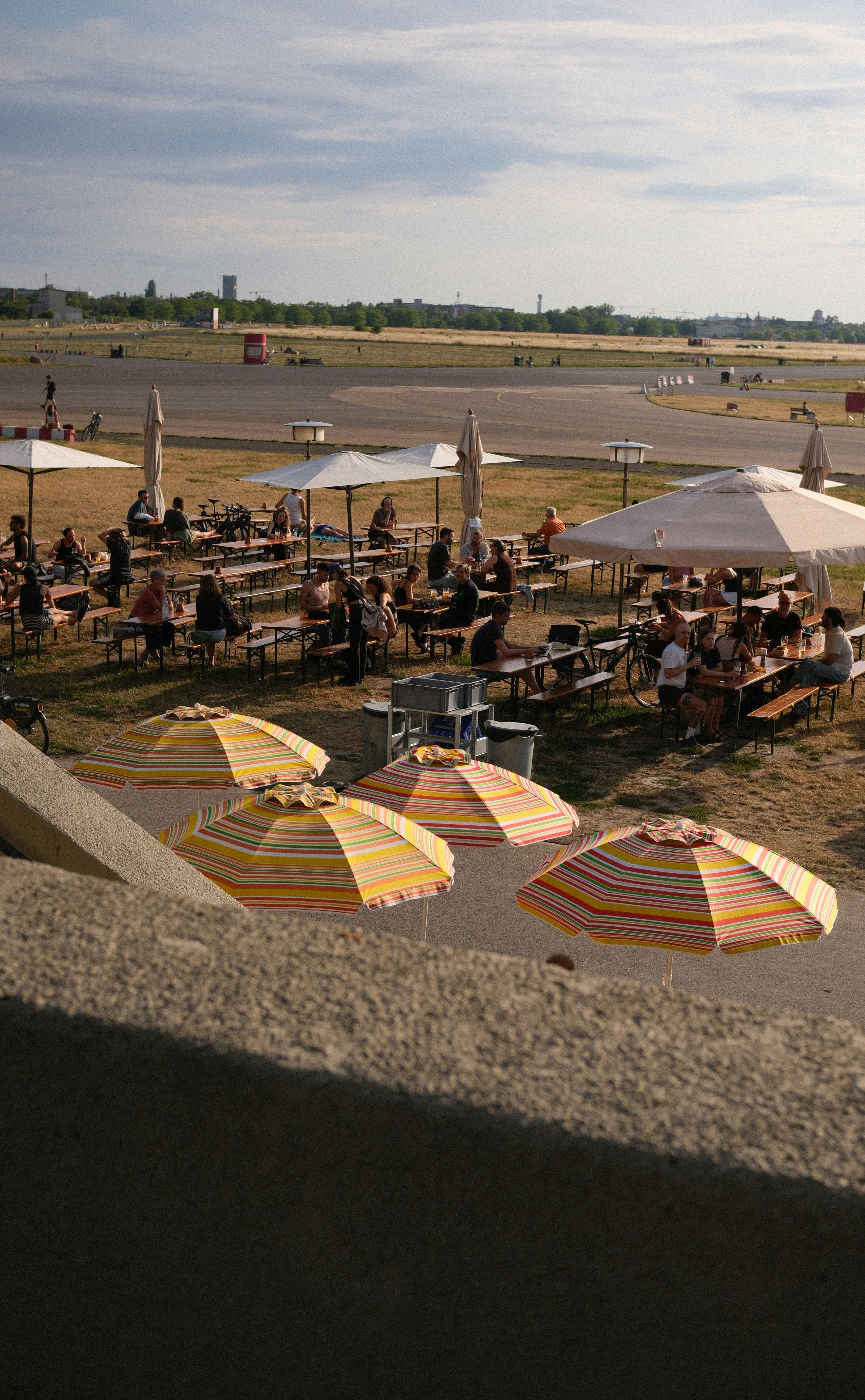 Sunlit Terrace: Stripes, Umbrellas, and Shared Moments