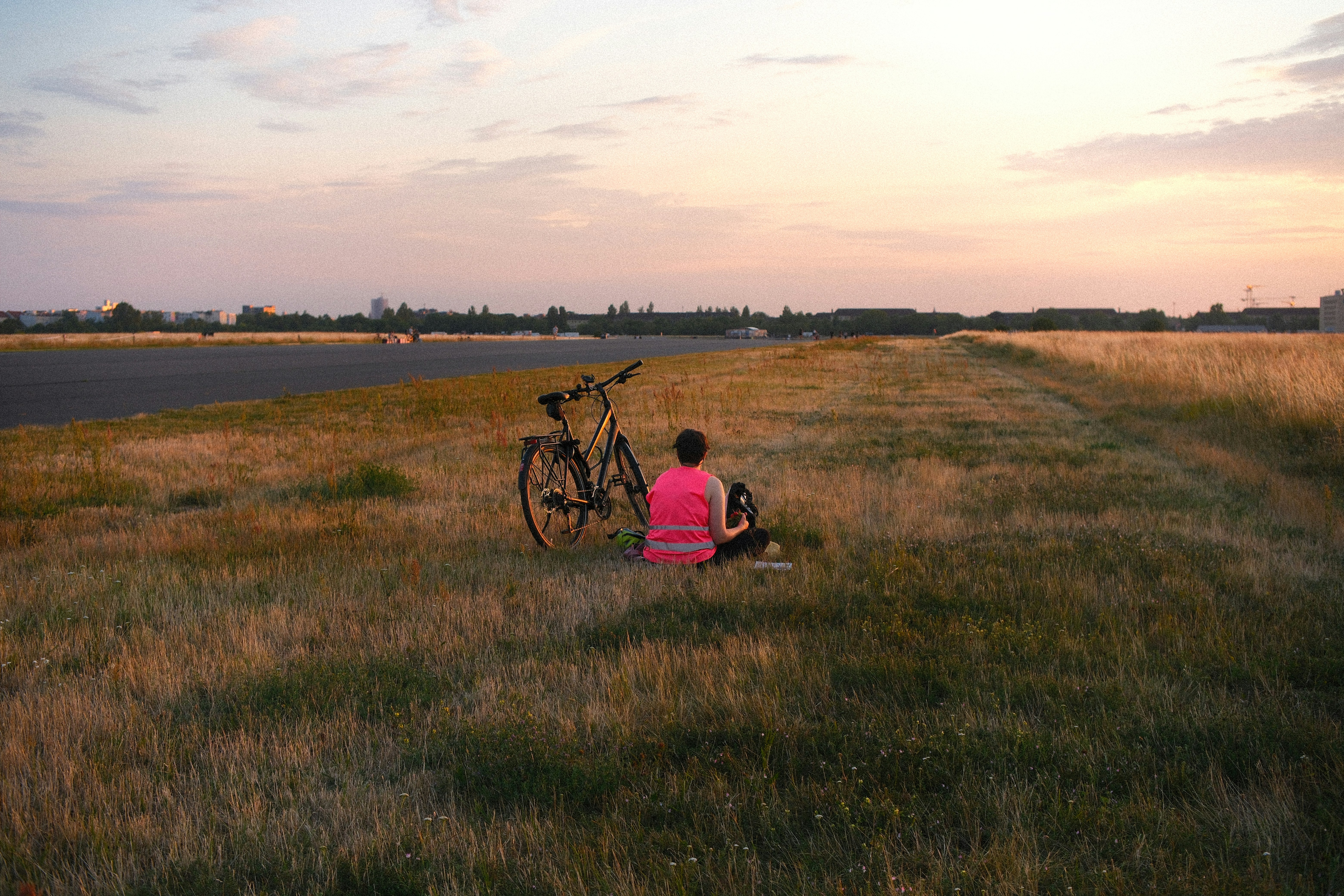 Quiet Moment After The Ride: A Biker and Companion Rest in Open Field