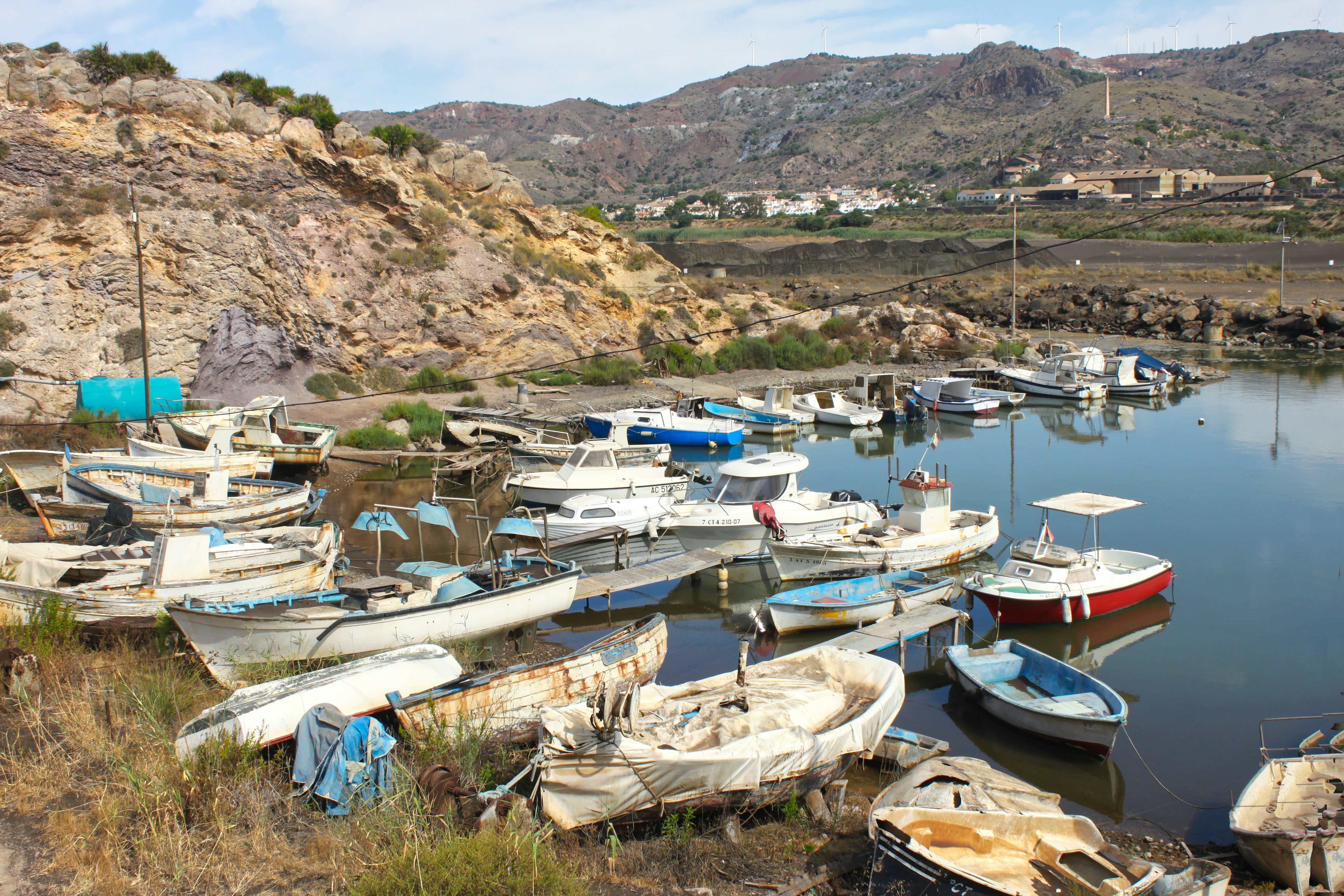 Dockside Mosaic: A Fleet of Quiet Boats Resting in a Rocky Cove