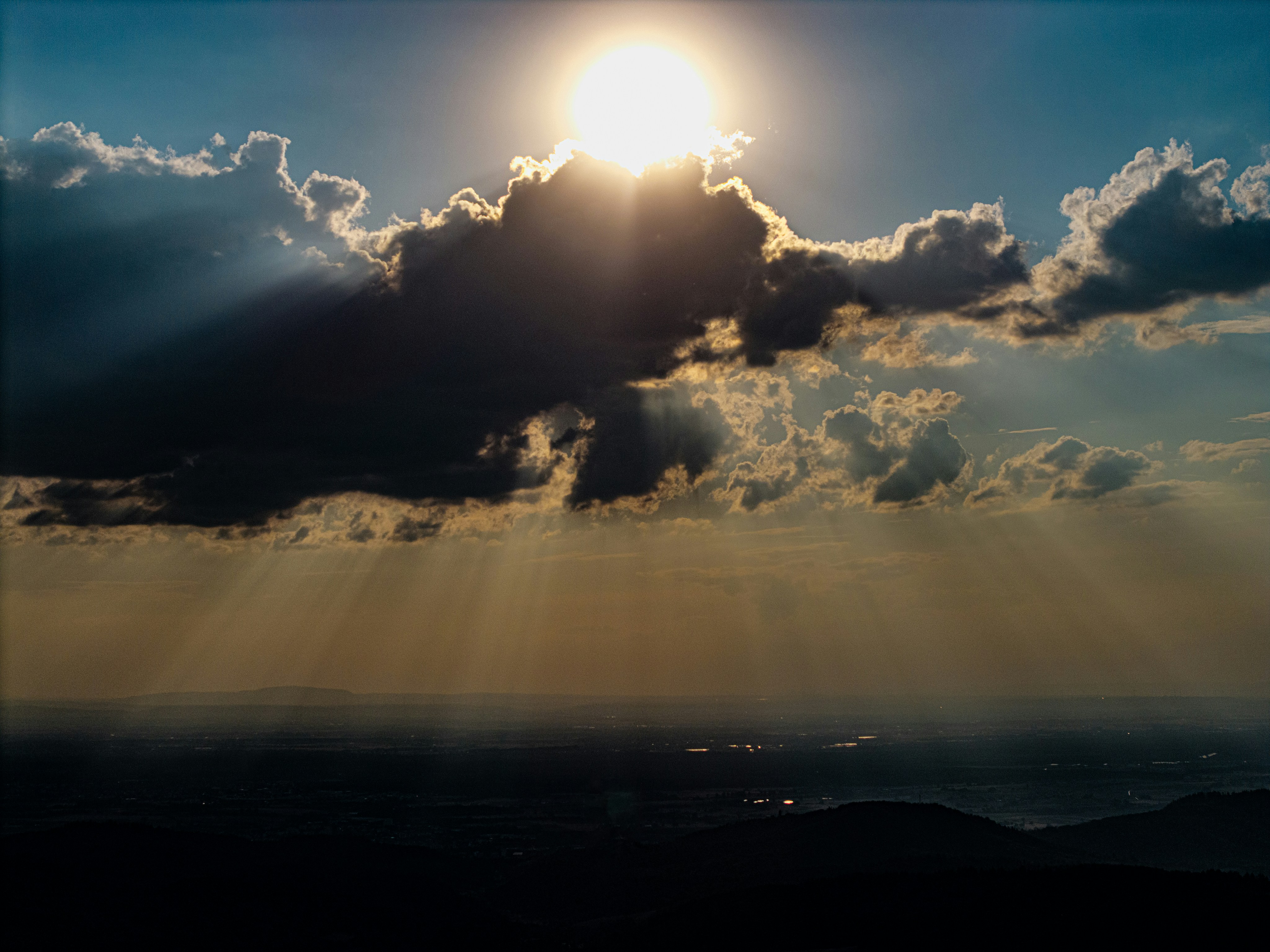 Sunburst Through a Cloud Crown over a Quiet Horizon