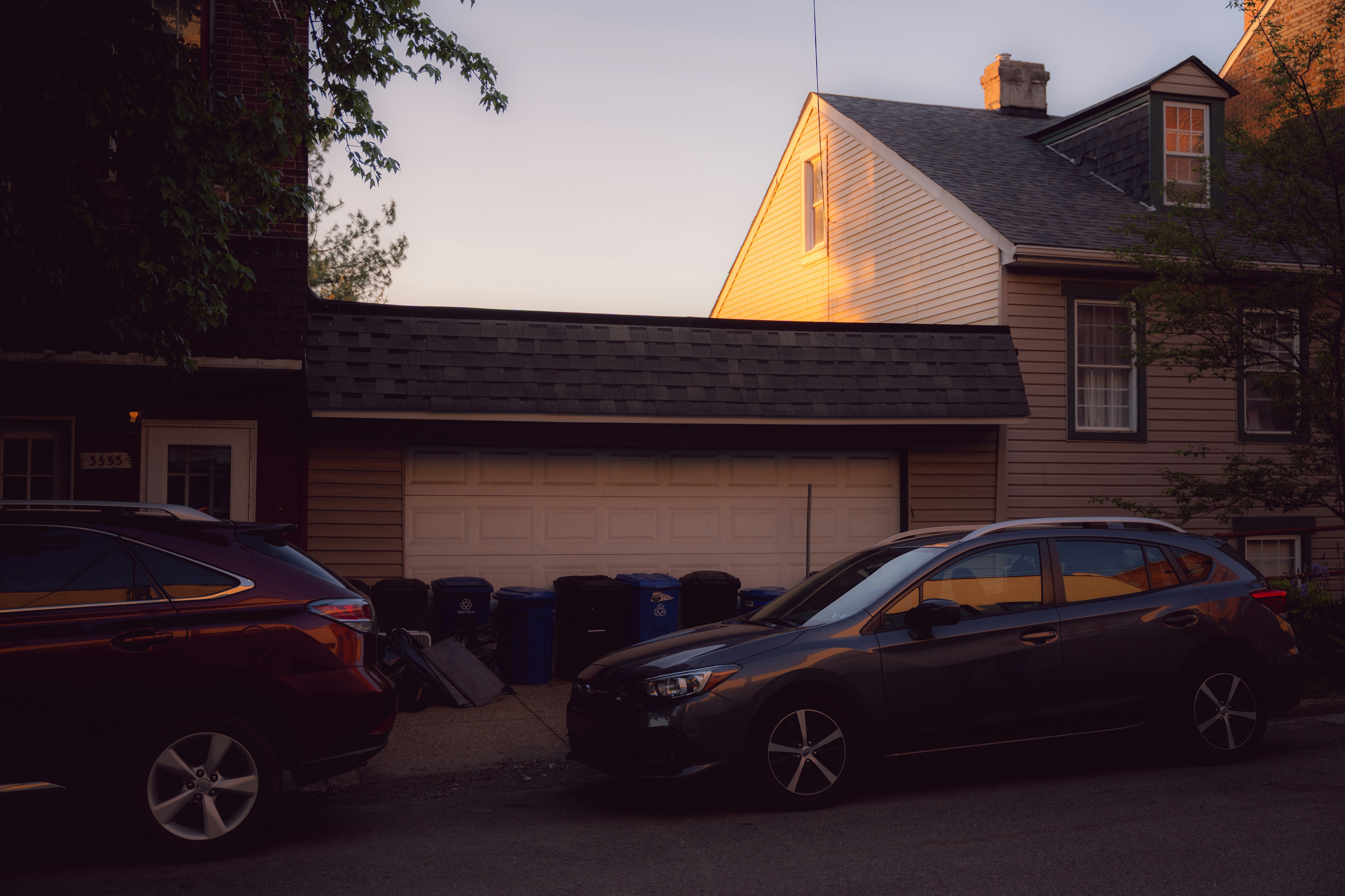 Last Light on the Drive: Cars and a Quiet Suburban House