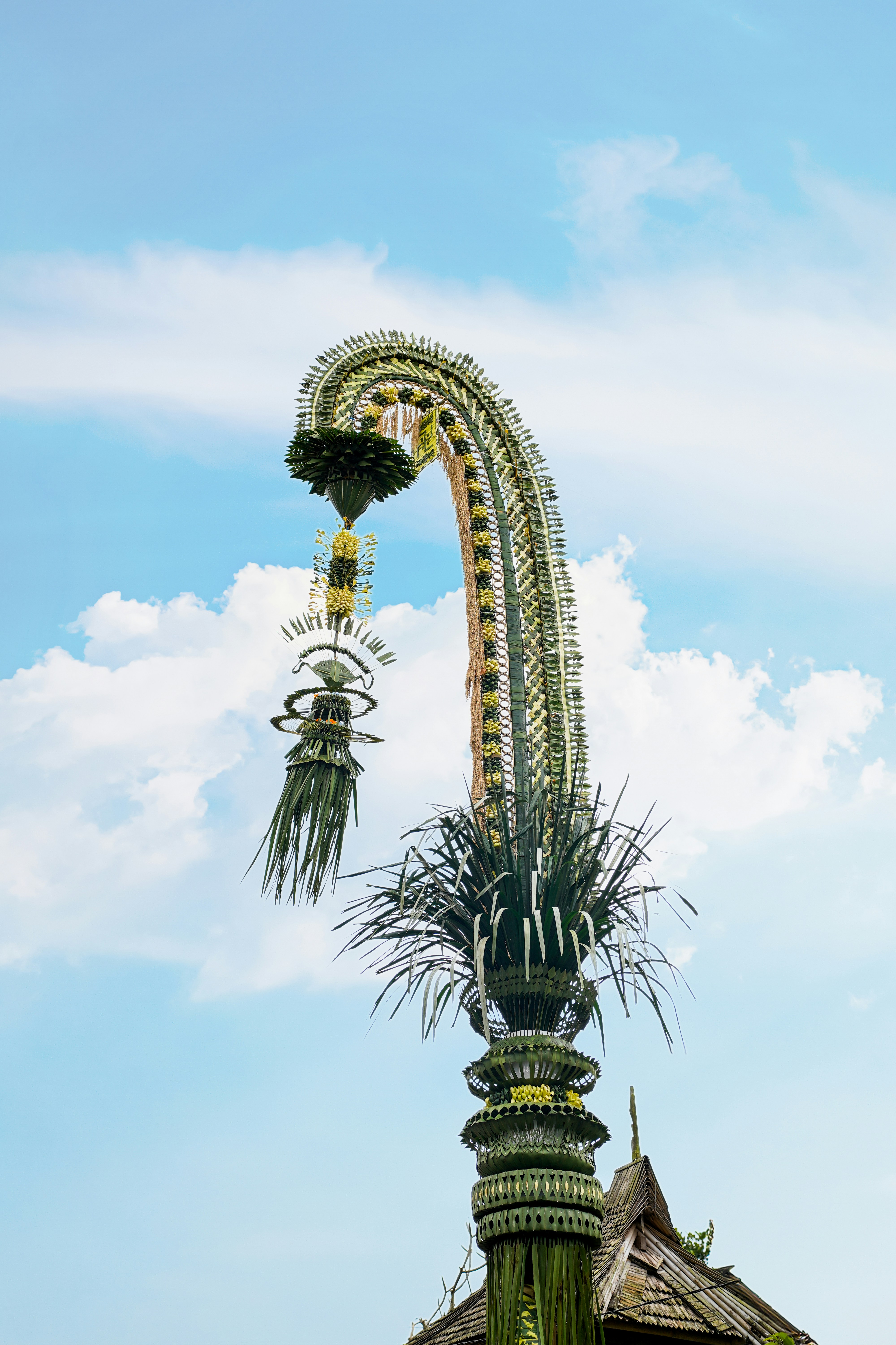 Dragon-esque arching ritual tower crowned with floral arrays against a cerulean sky