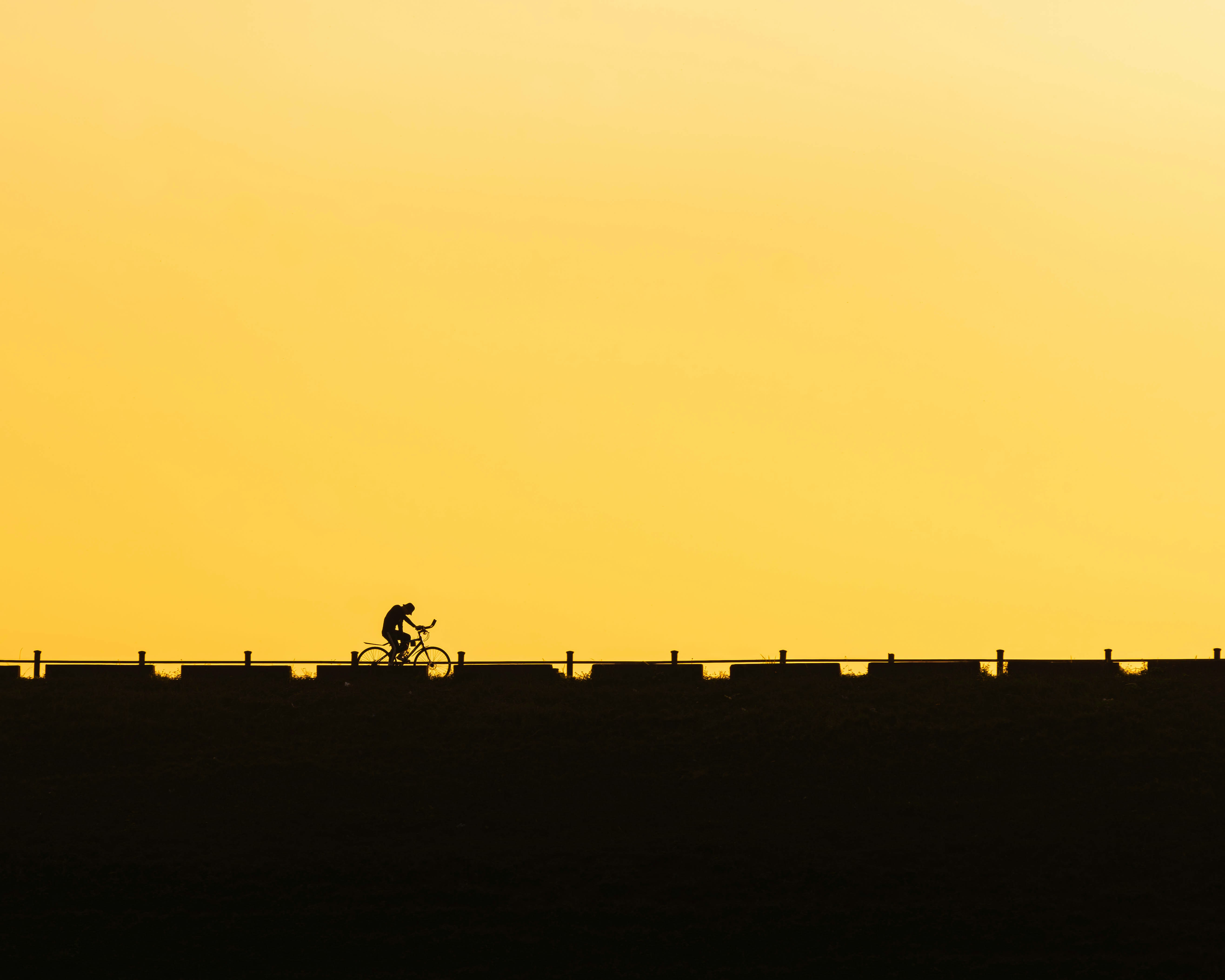 Midnight Rider: A lone cyclist traces the horizon at sunset