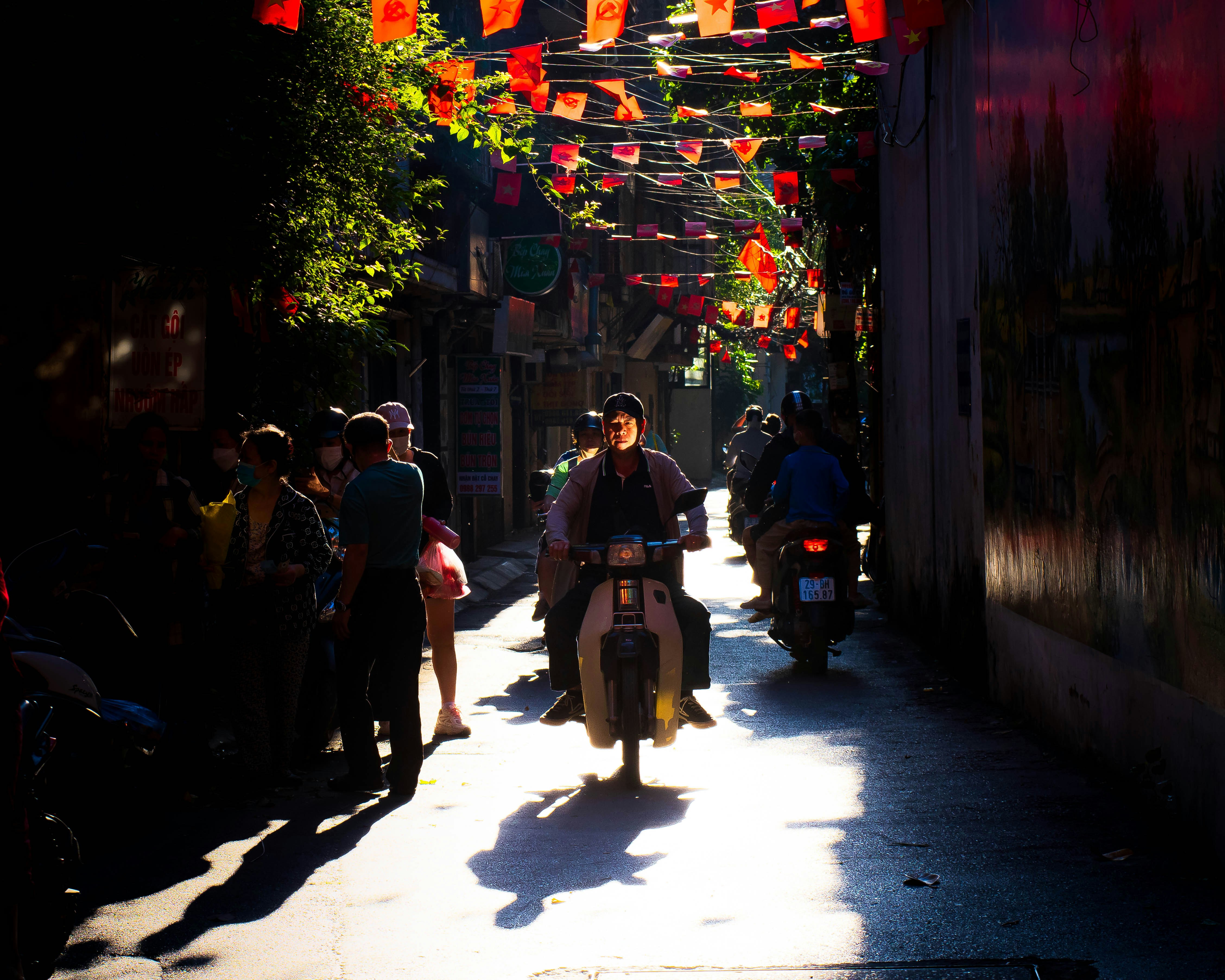 Sunlit Alley Commute: A Scooter Dash Through a Colorful Street