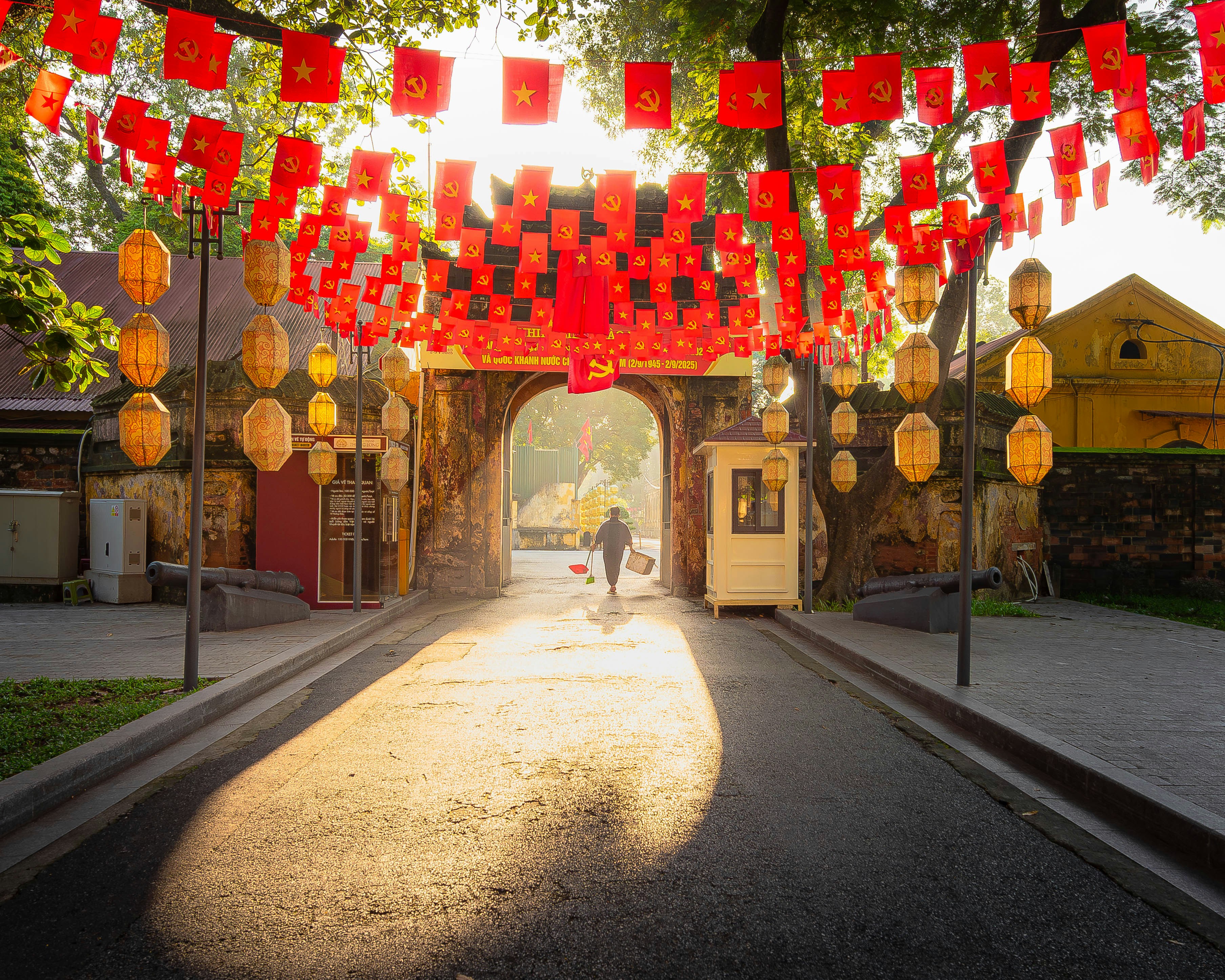 Sunlit Gate: Lanterns, Flags, and a Lone Pedestrian