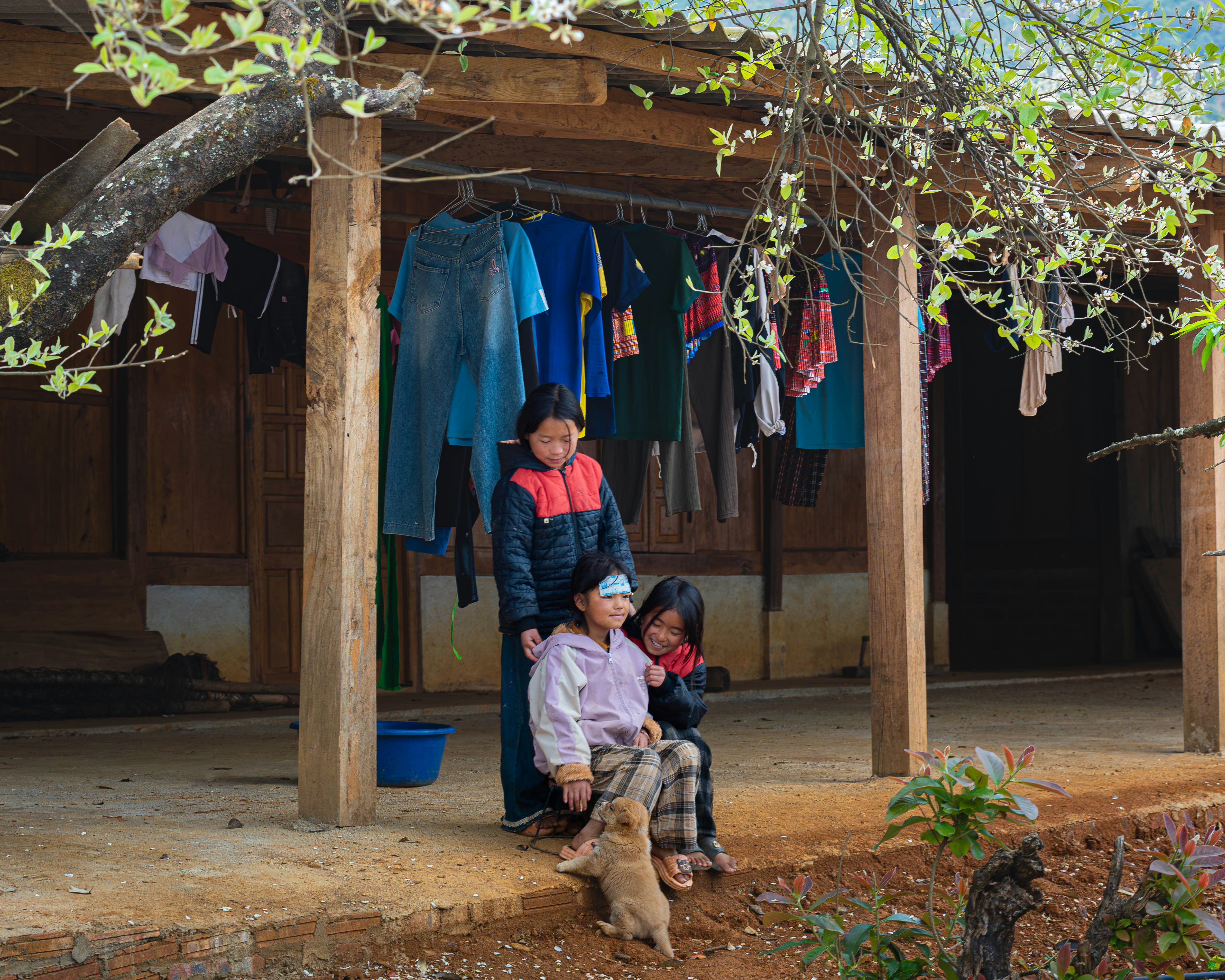 Three Generations in a Courtyard: A Quiet Moment with a Pet by the Laundry