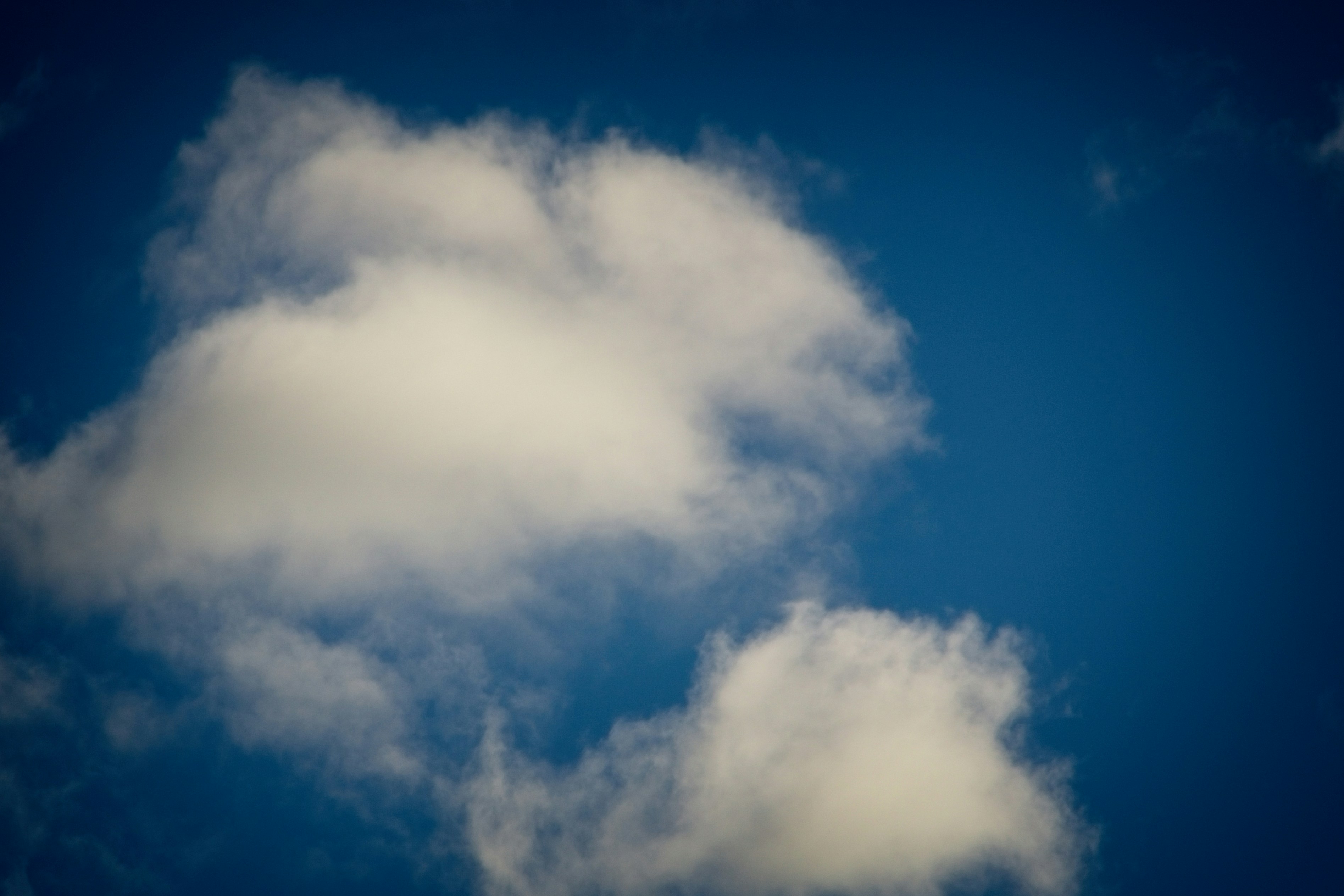 A Quiet Azure: Clouds Drift in a Clear Sky