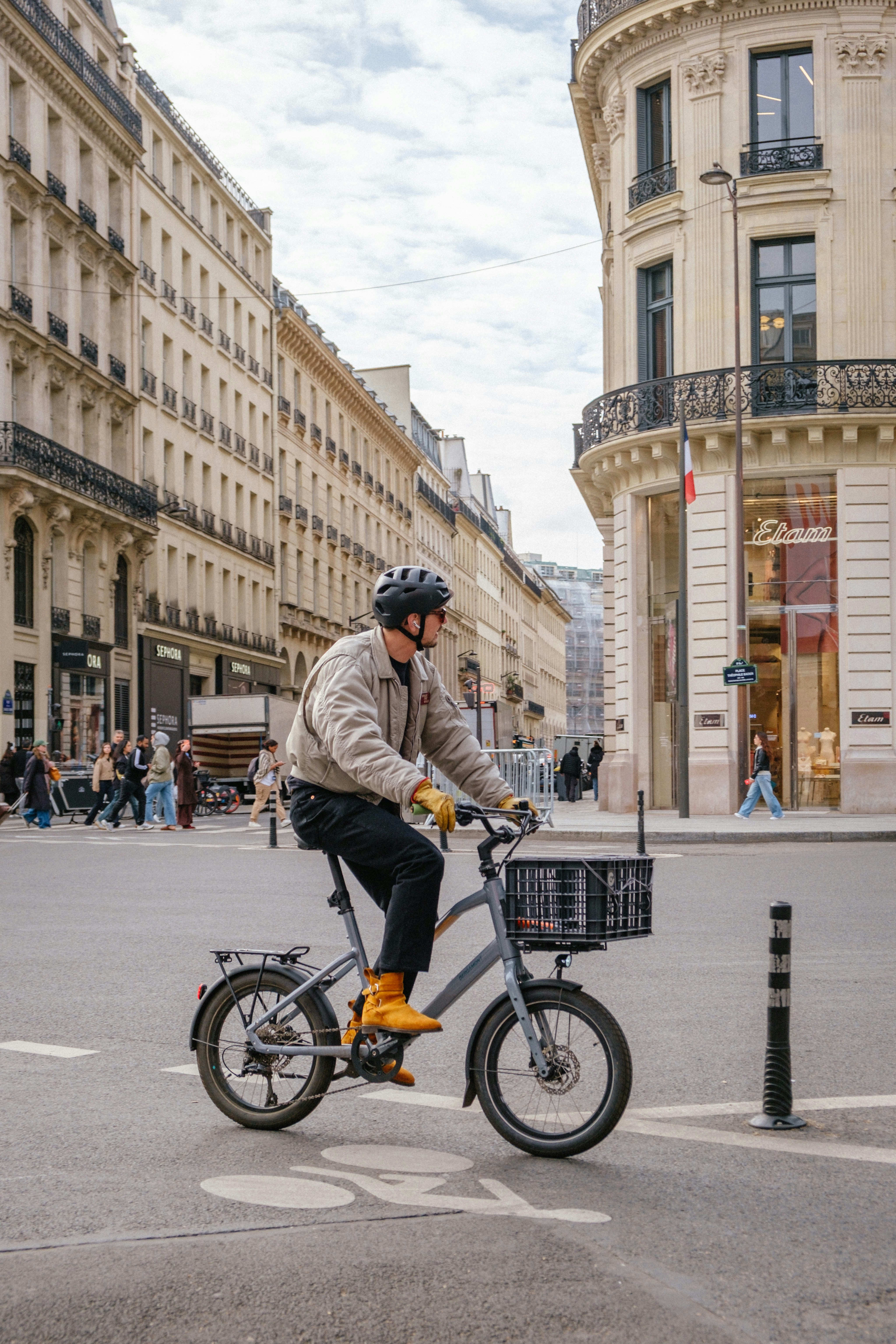 Urban Ride: A commuter cyclist crosses a Parisian avenue