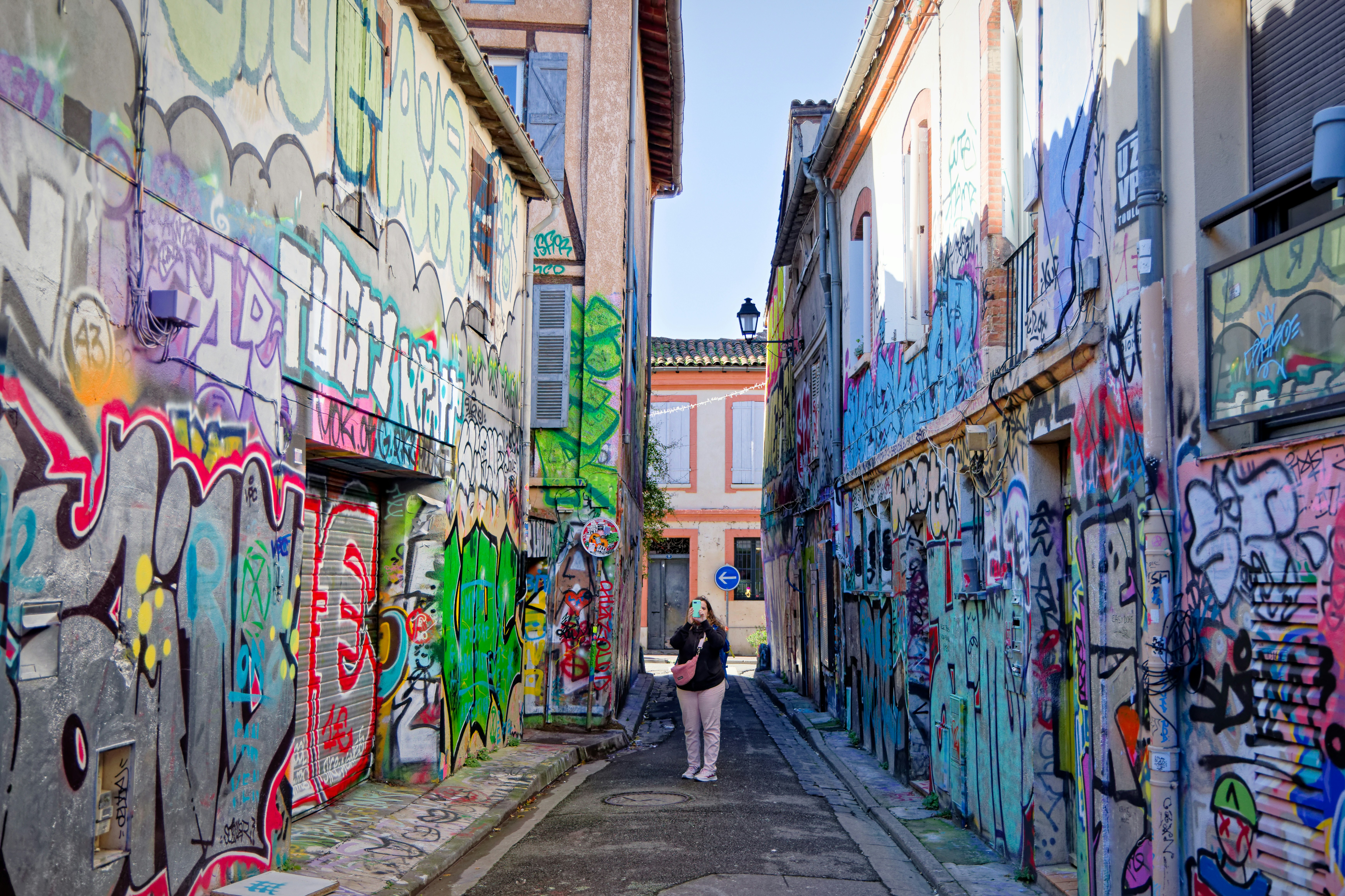 Graffiti Alleyways: A Sole Figure Framed by Colorful Walls