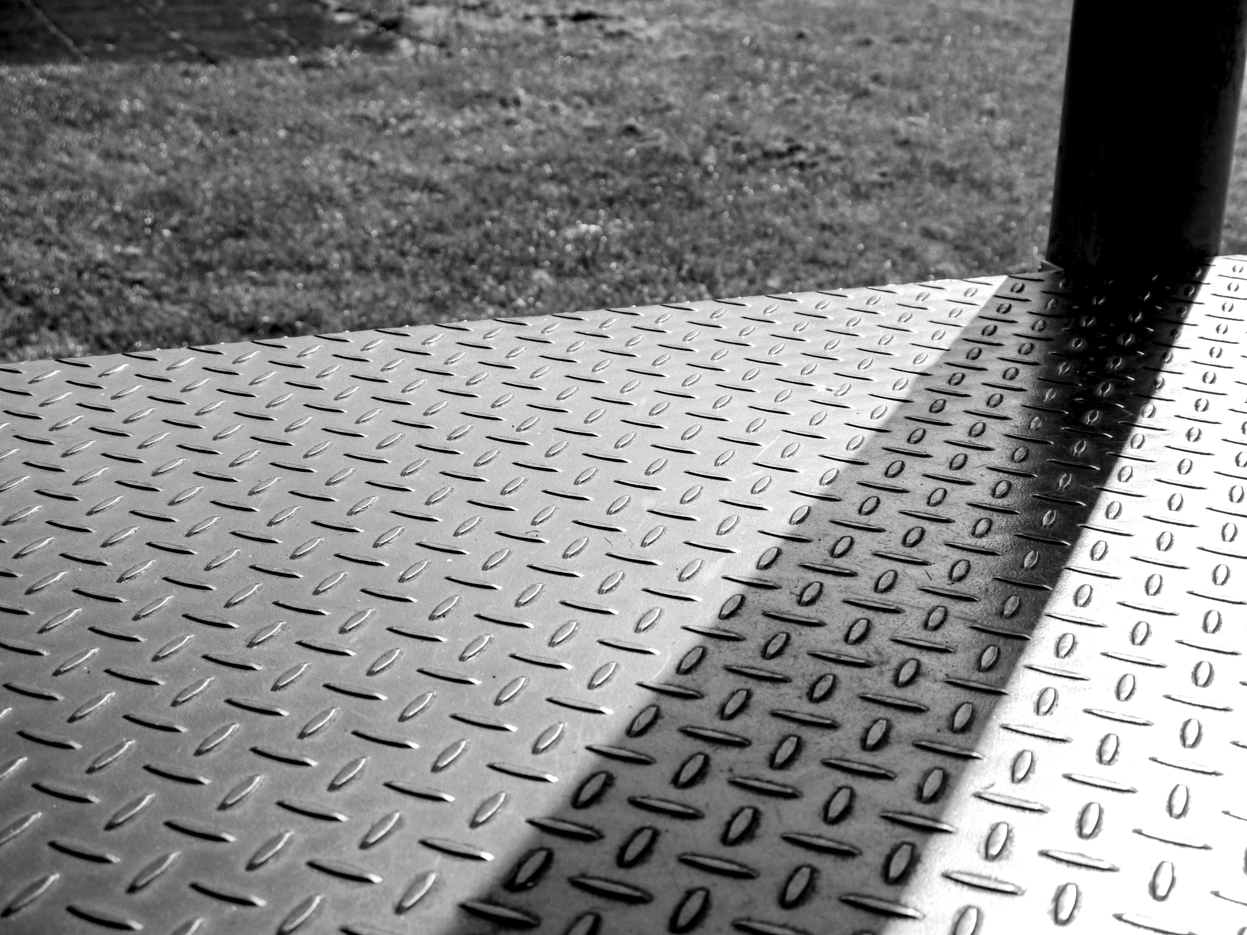 Industrial Pattern: Diamond-Plate Geometry Under a Park Shadow