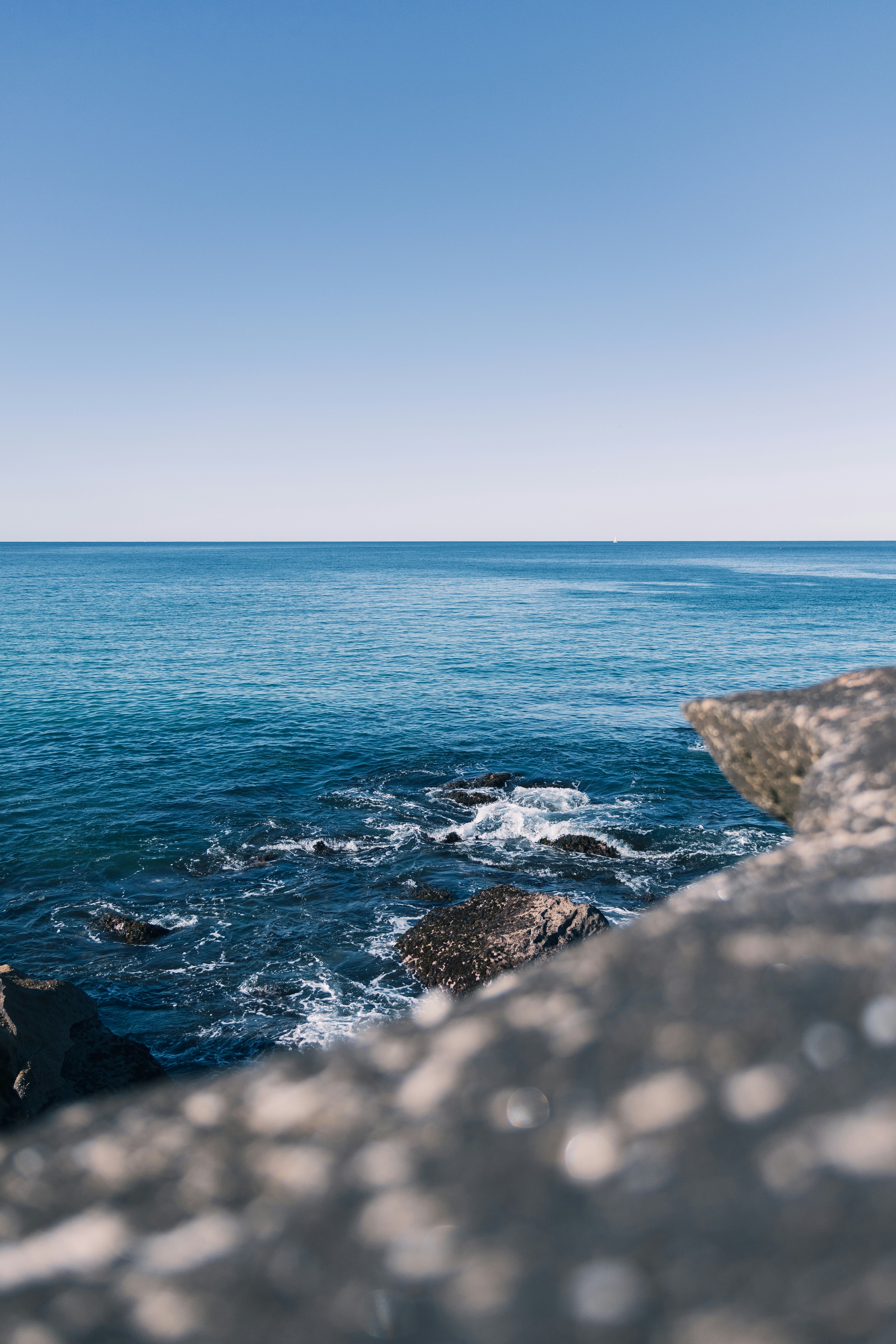 Blue Horizon over Quiet Sea: A Seascape Framed by Weathered Rocks