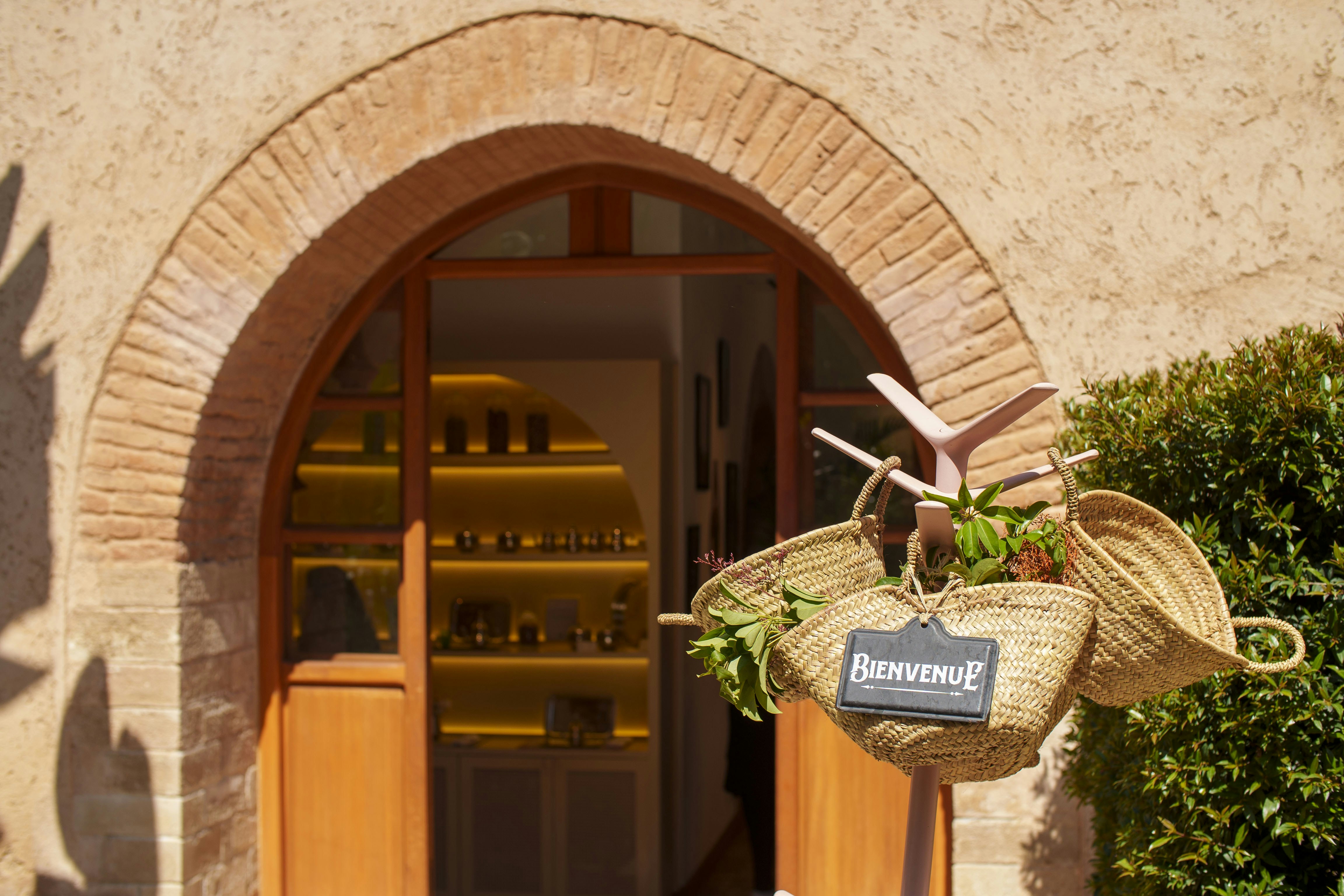 Merci de Bienvenue: The Basket Sign at Dawn over a Sunny Shop Door