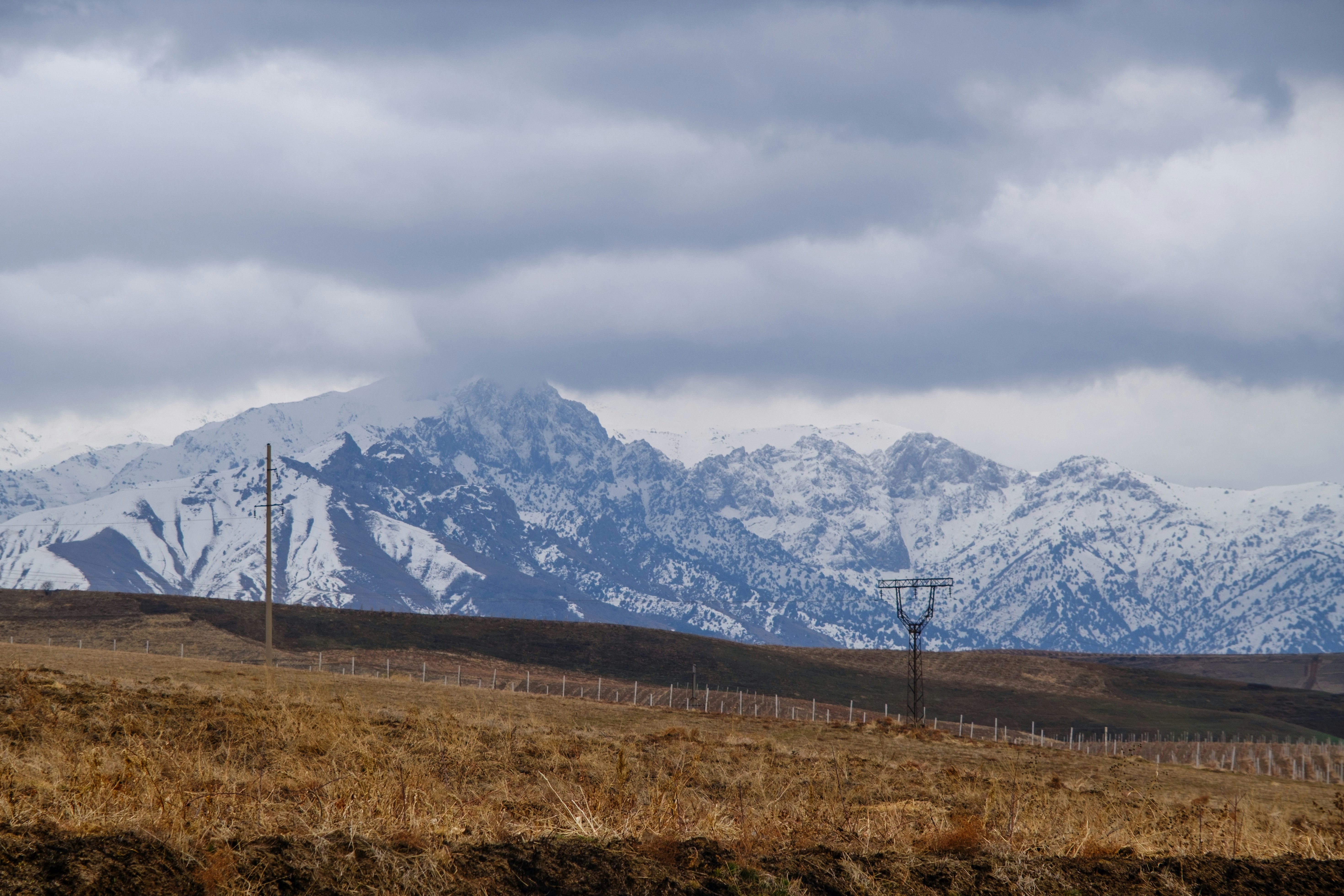 Snowcaps and open plain under moody skies