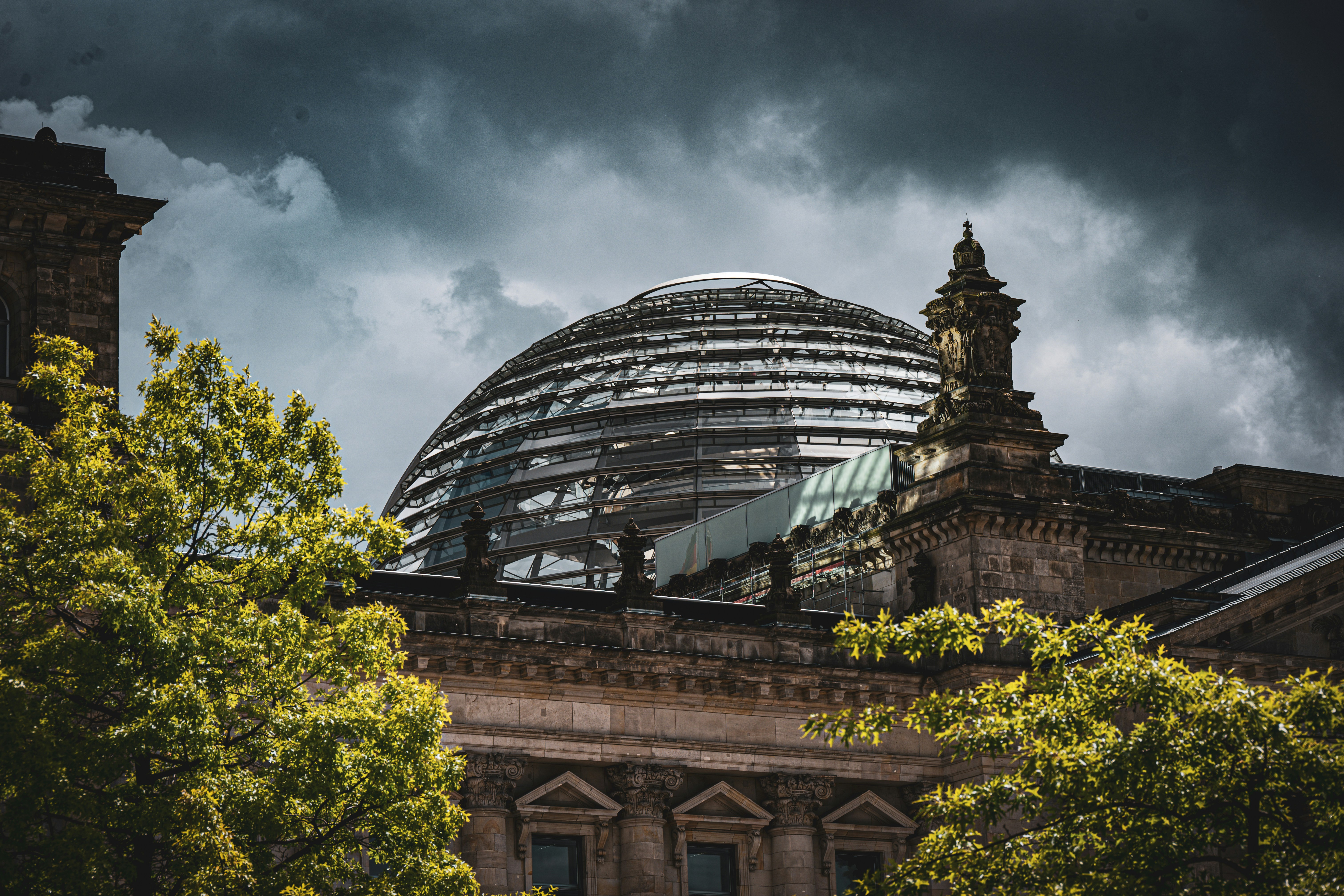 Glass Dome Above Historic Facade: Sunlit Truce Between Stone and Sky