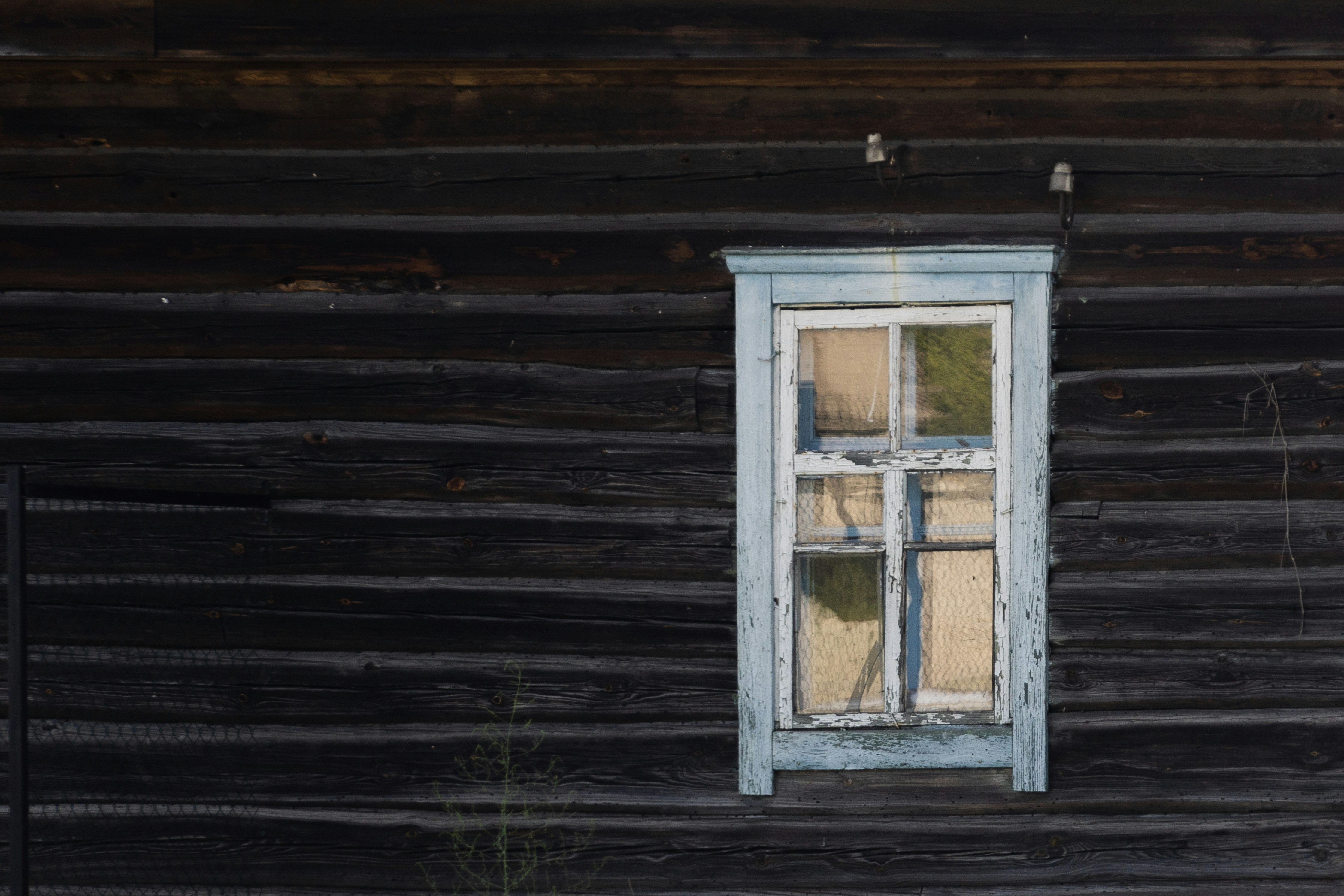 Weathered Window in a Dark Timber Wall