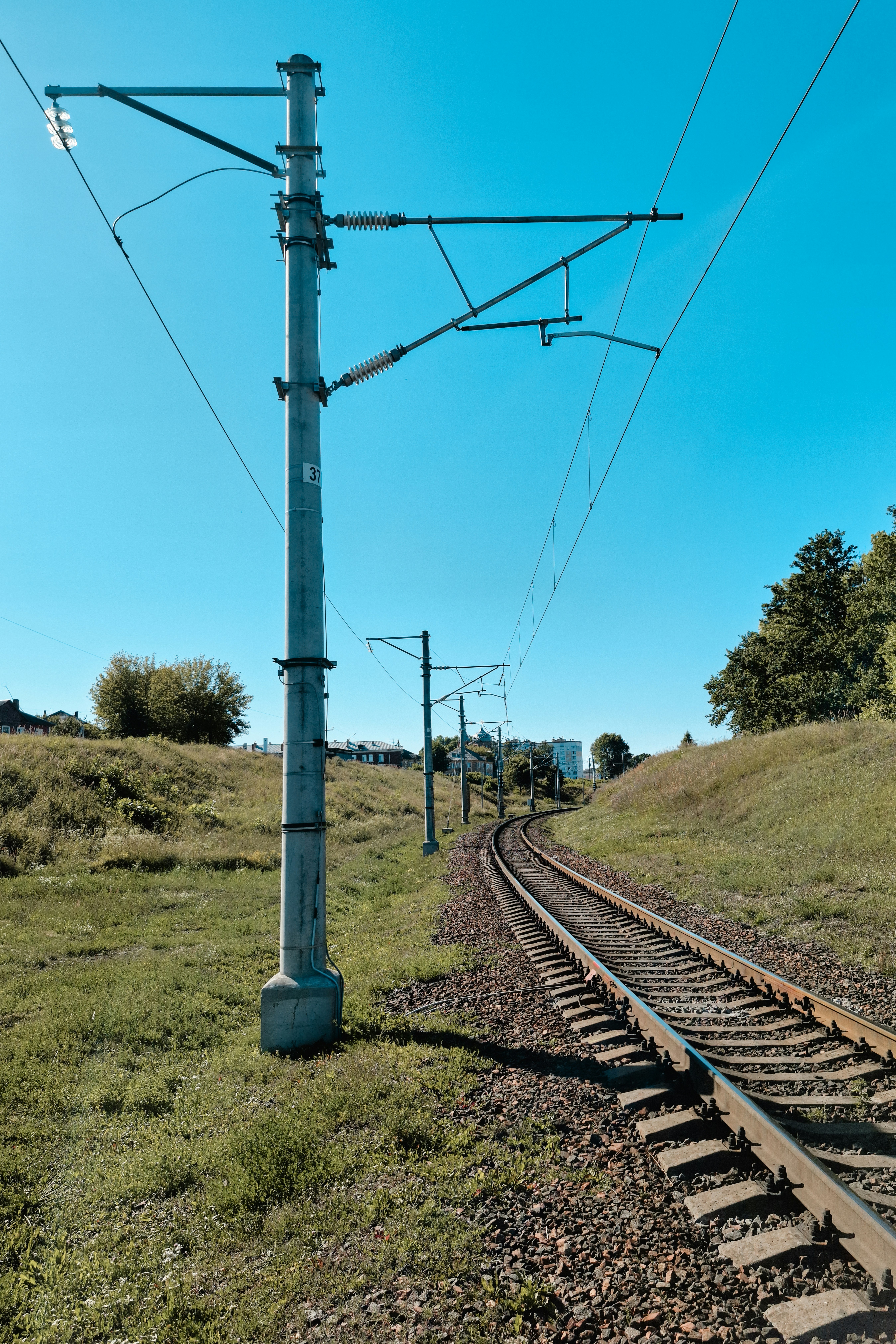Railway Veins: A Lone Track Reaches Toward A Horizon of Power Lines