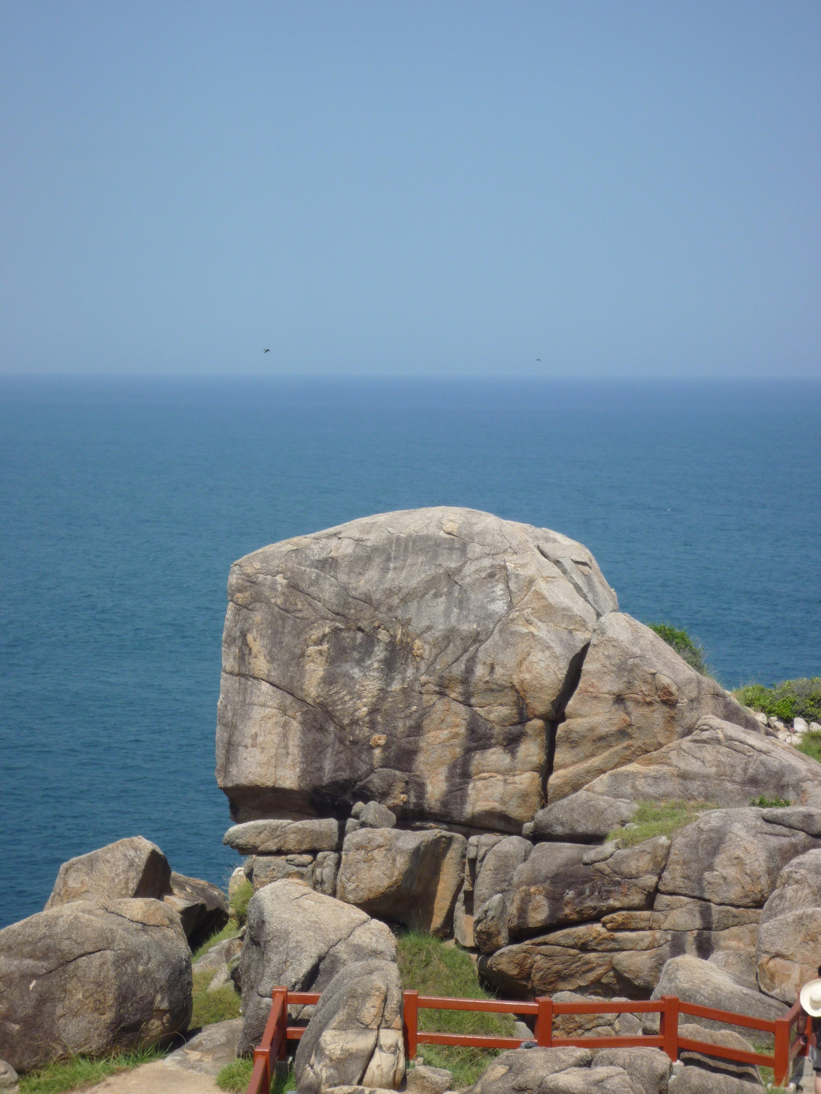 Coastal Sentinel: A Weathered Rock Overlooking the Sea
