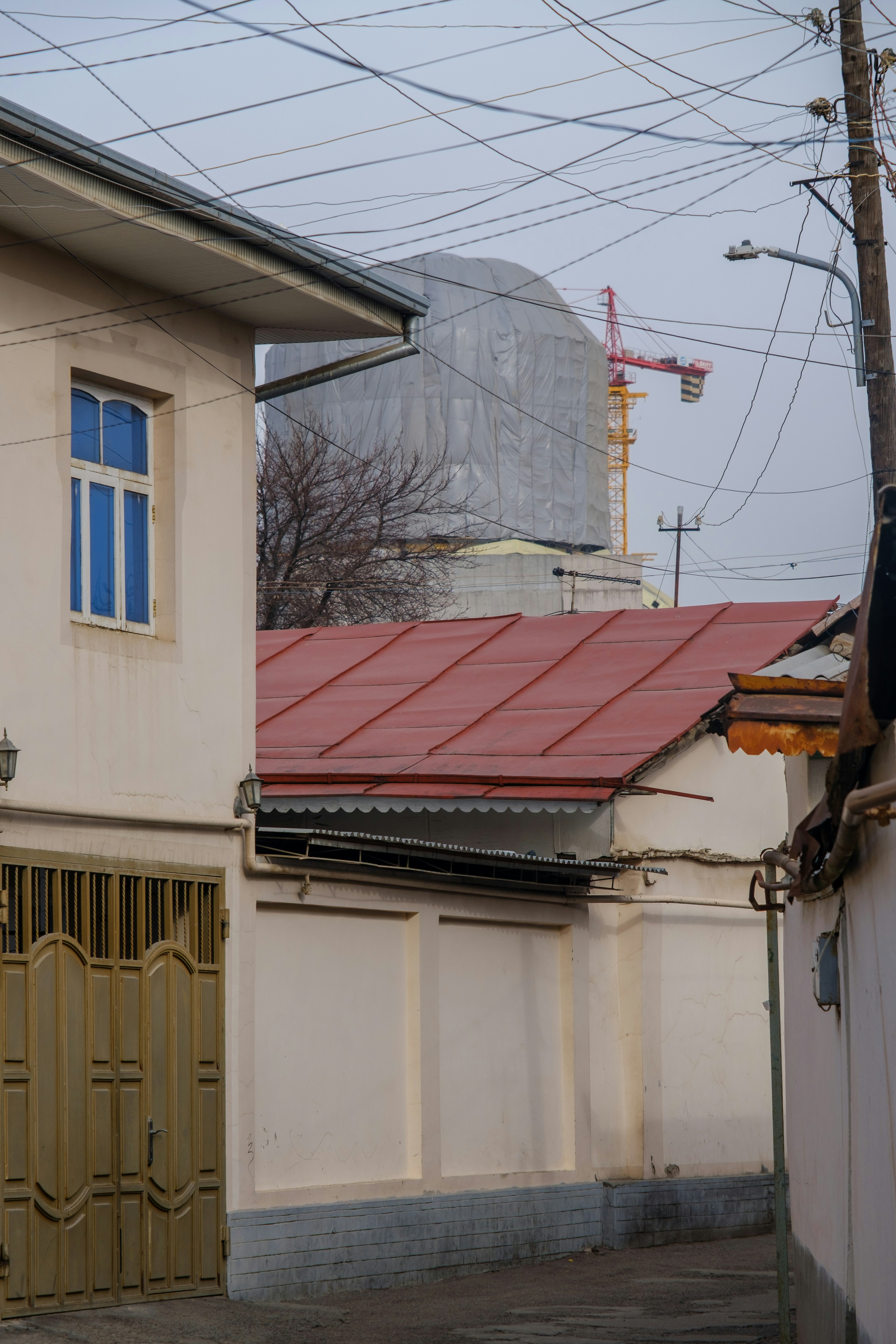 Rooftops and Wires: An Urban Snapshot Beneath a Crane