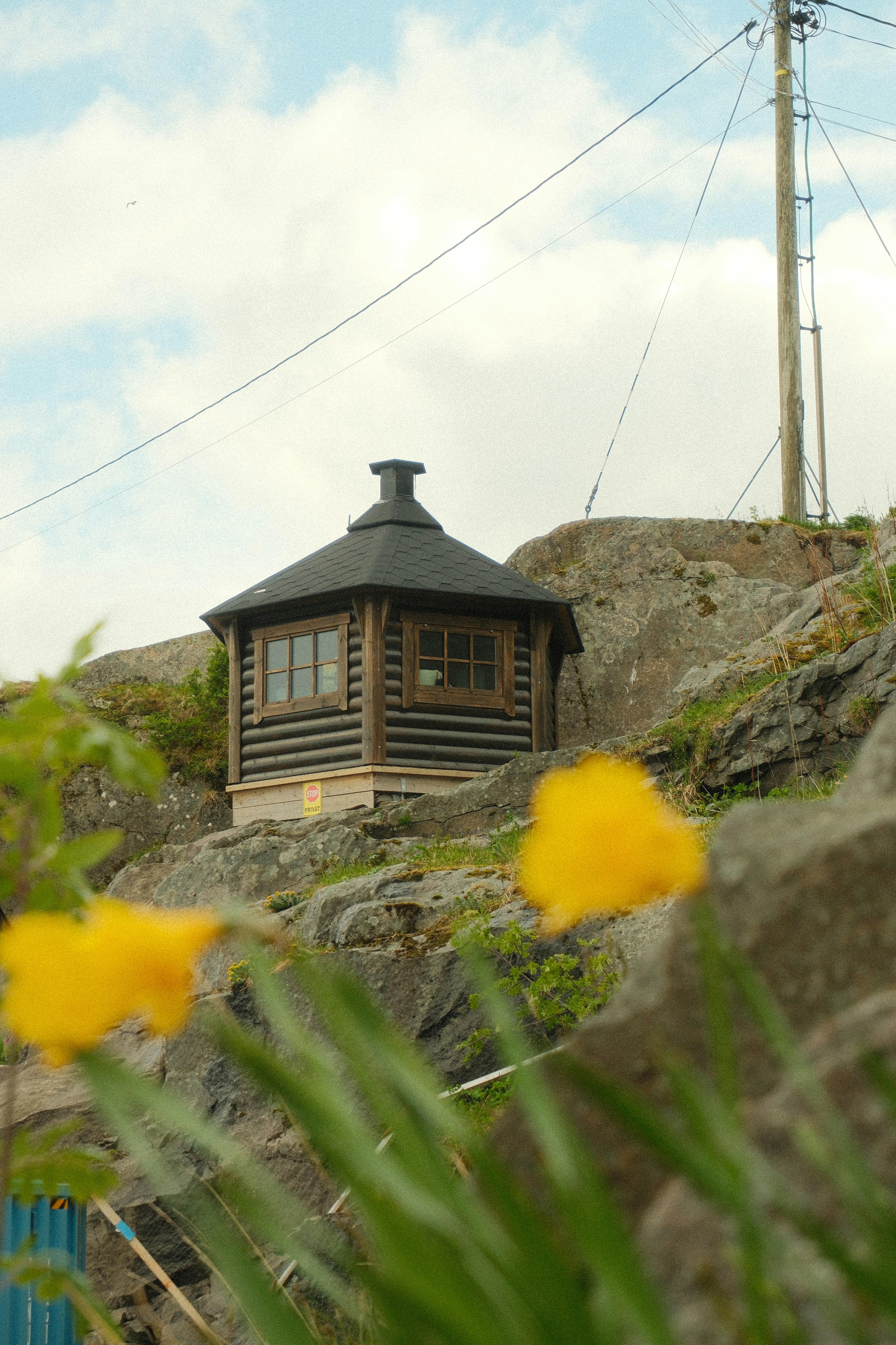 Wooden Cabin on Granite Ridge Under a Sky of Soft Clouds