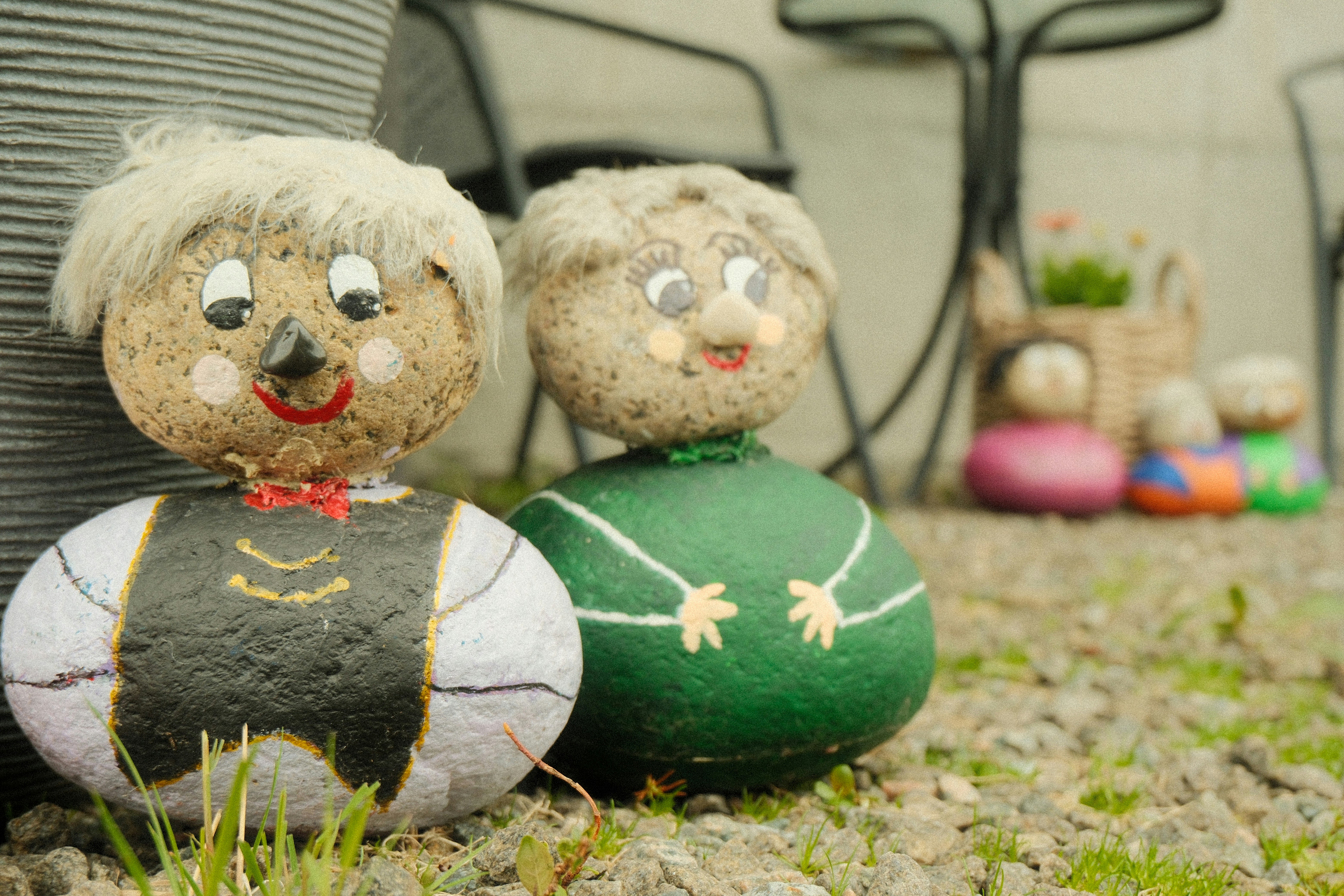 Cheerful Pebble Couple: Smiling Sculptures Guarding a Tiny Garden
