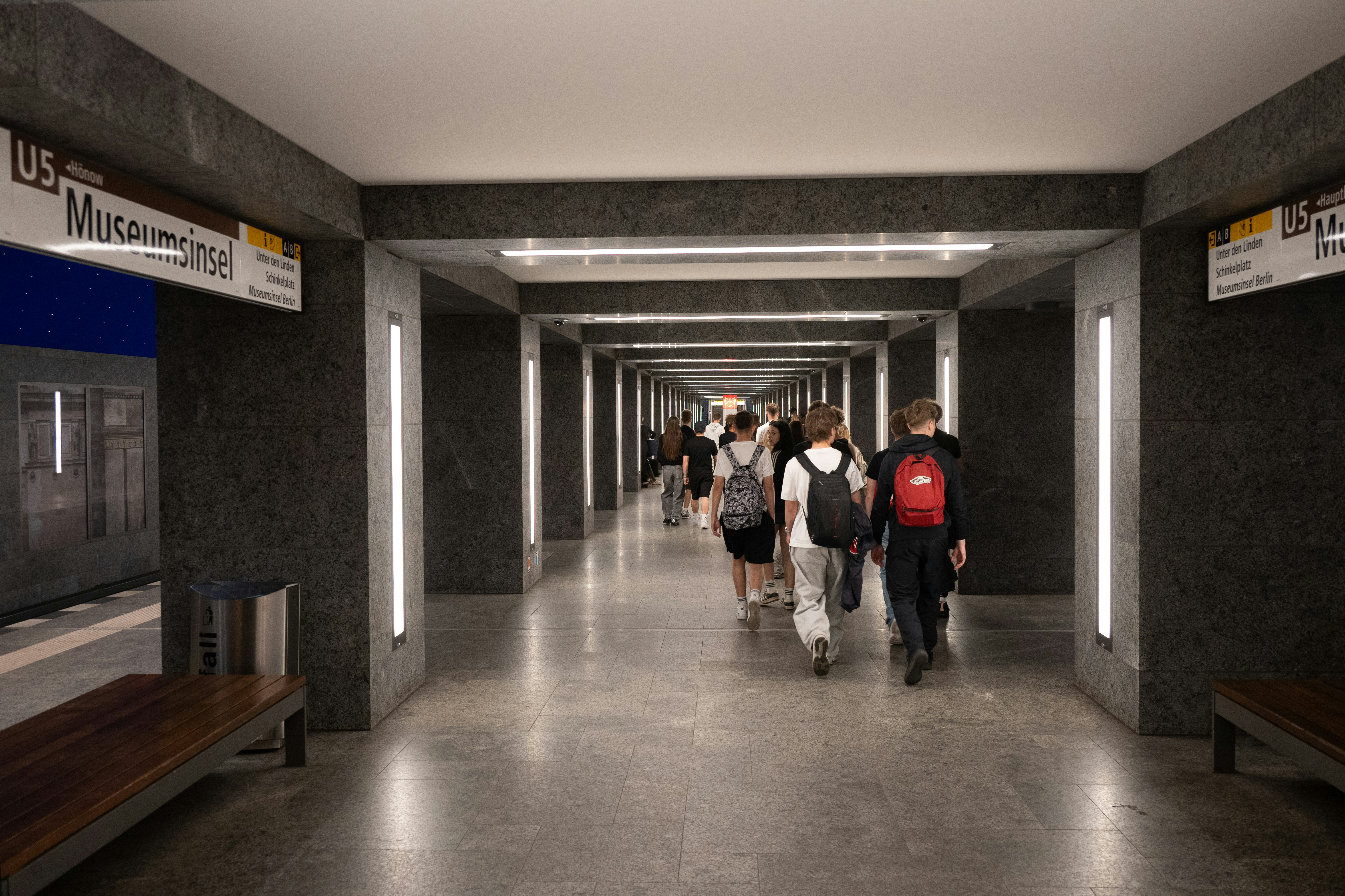 Railway Corridor of Echoes: Travelers Walk the Subterranean Path