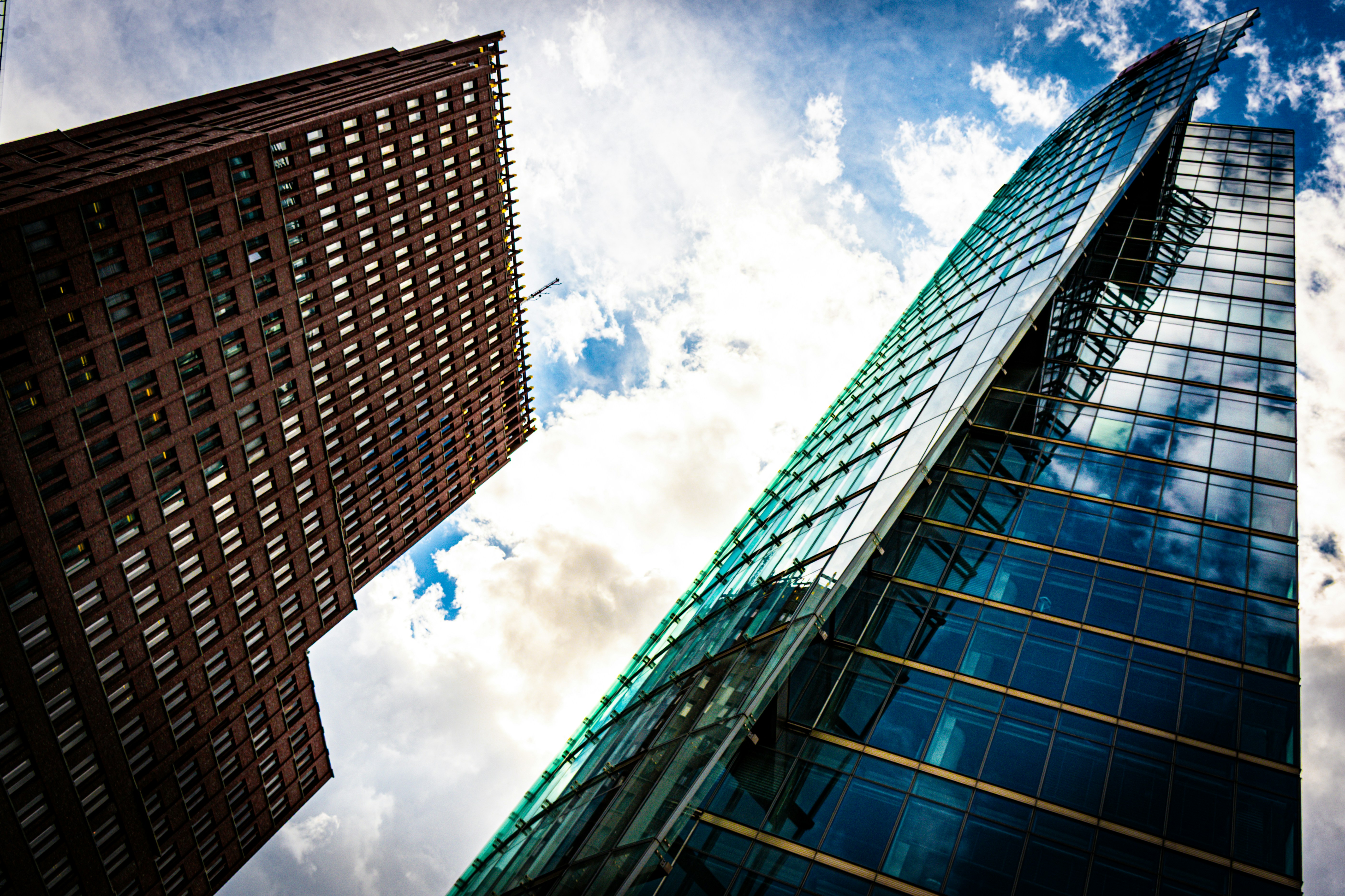 Tilted Giants: Glass Facades Reaching Toward a Pink-Blue Sky