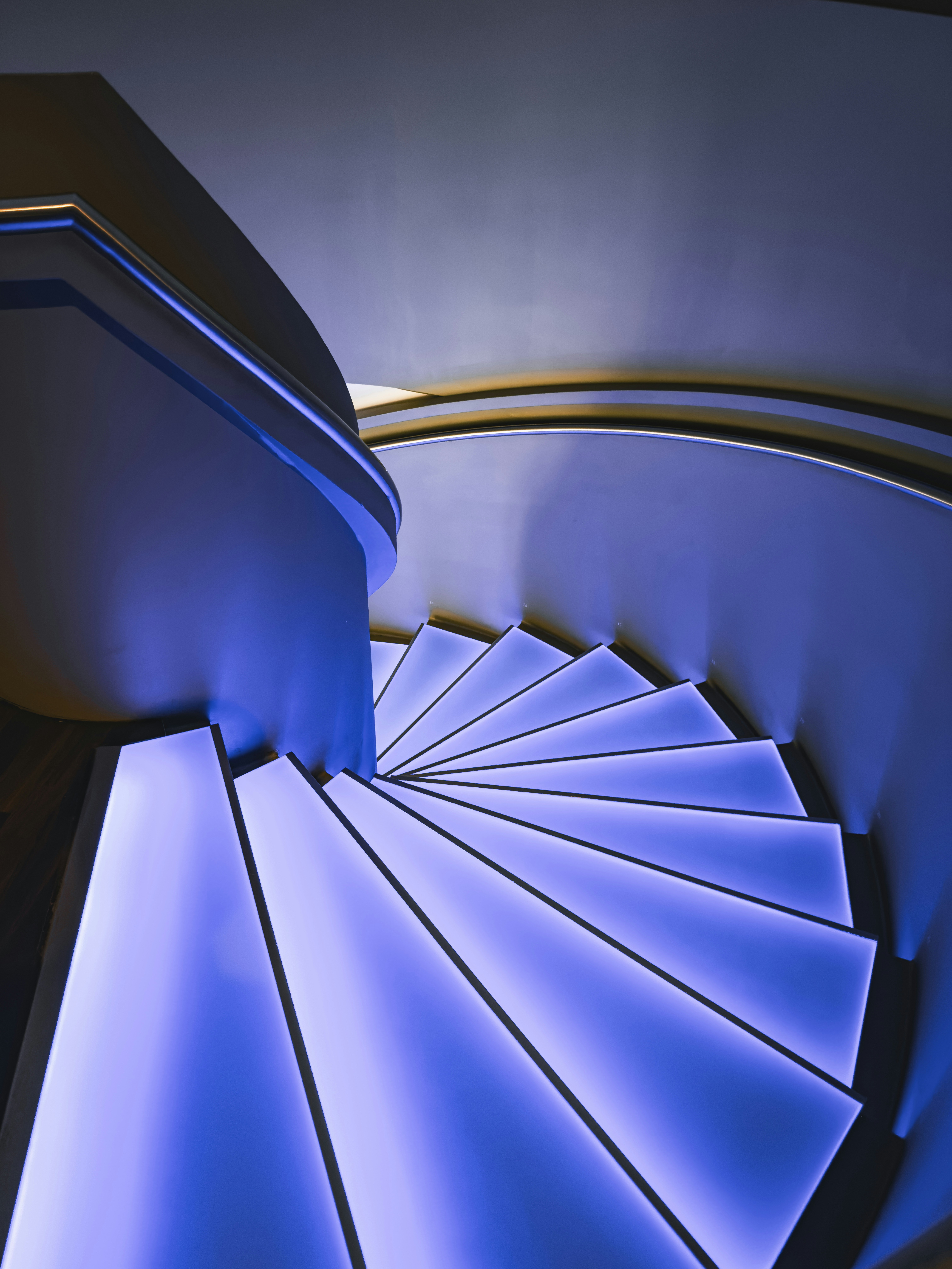 Neon Spiral: Blue-Illuminated Staircase Draws the Eye