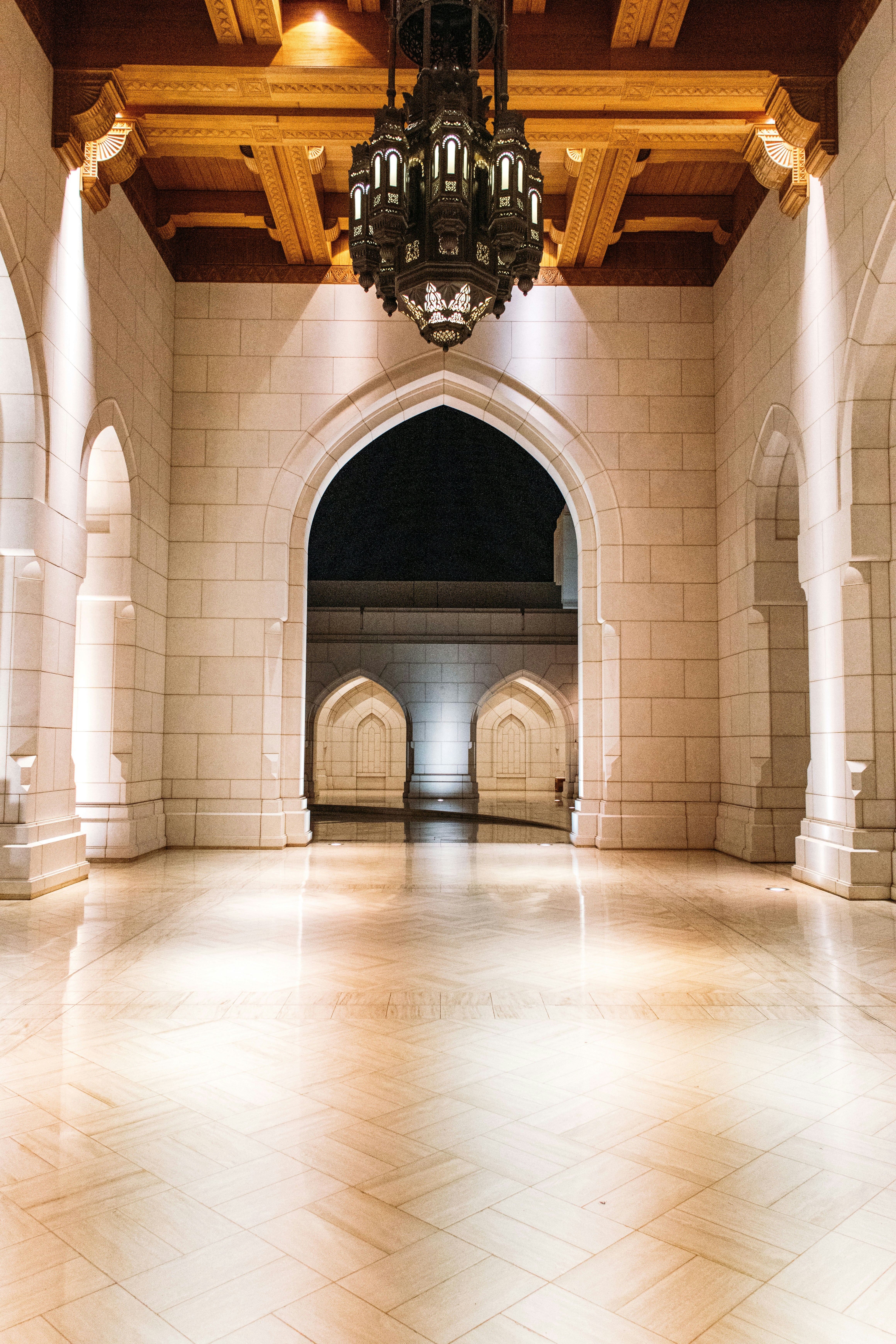 Lanterned Archway Hallway under Ornate Ceiling