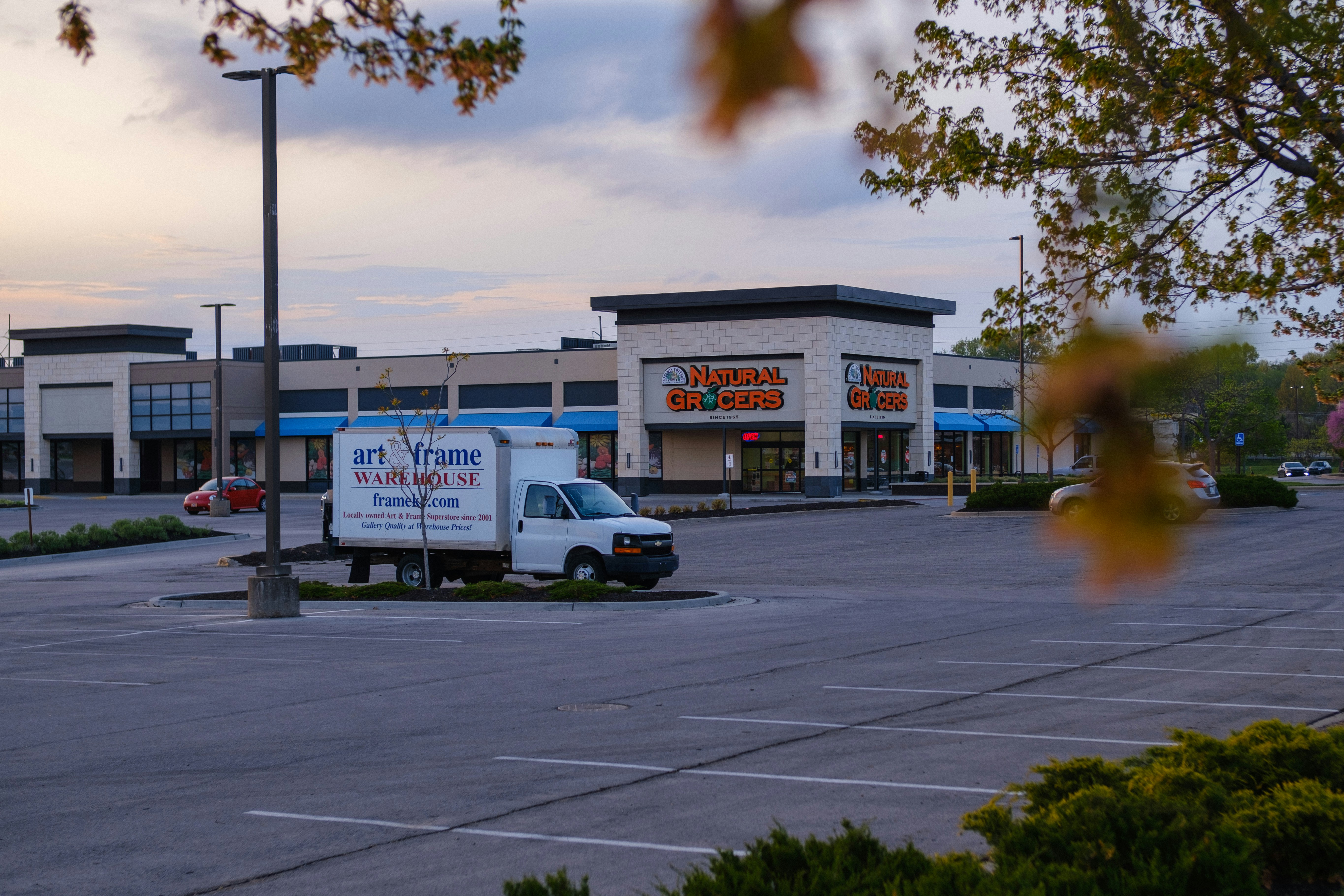 Quiet Strip Mall at Dusk: A Parking Lot View with a Delivery Van